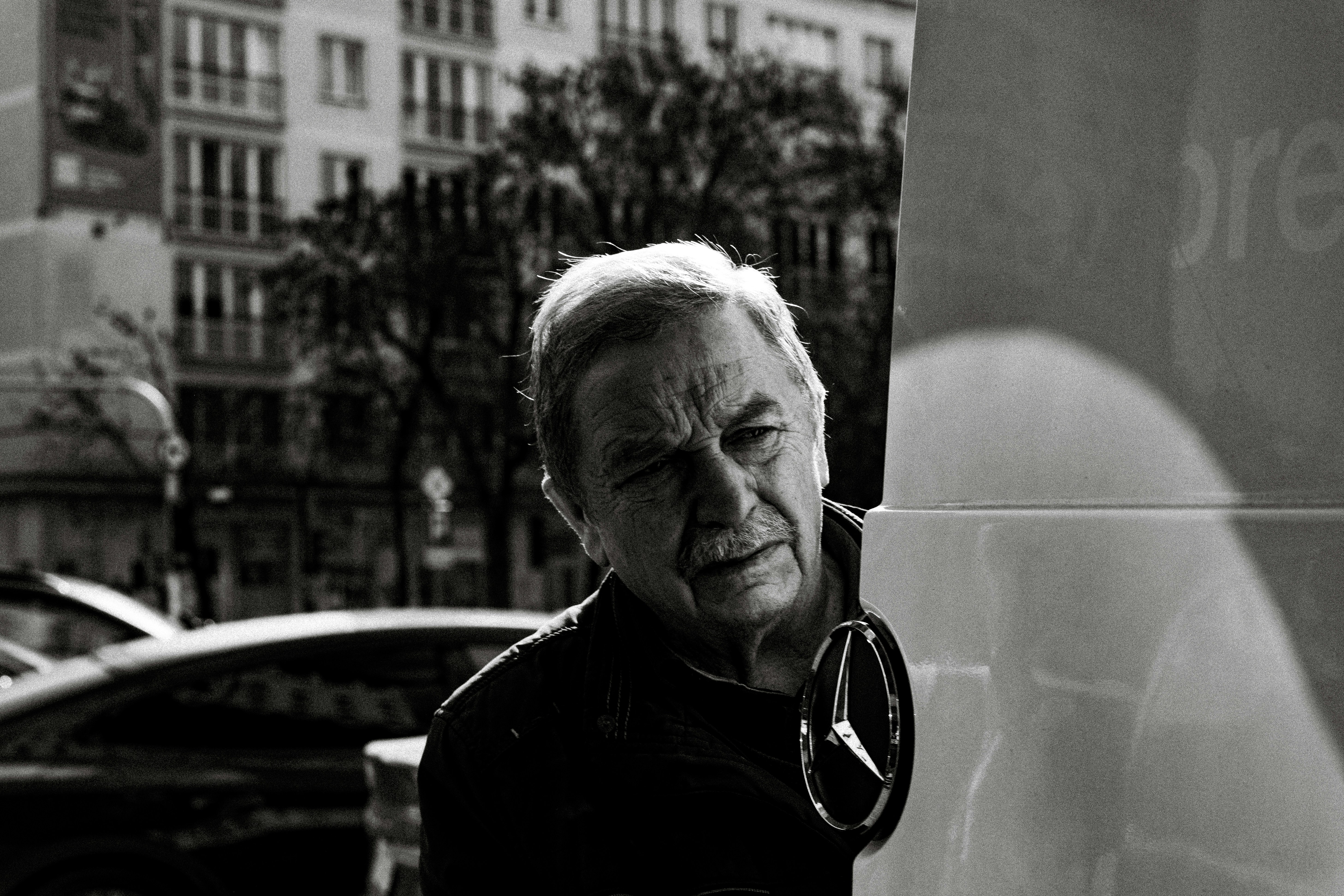A weathered gaze behind the urban glass