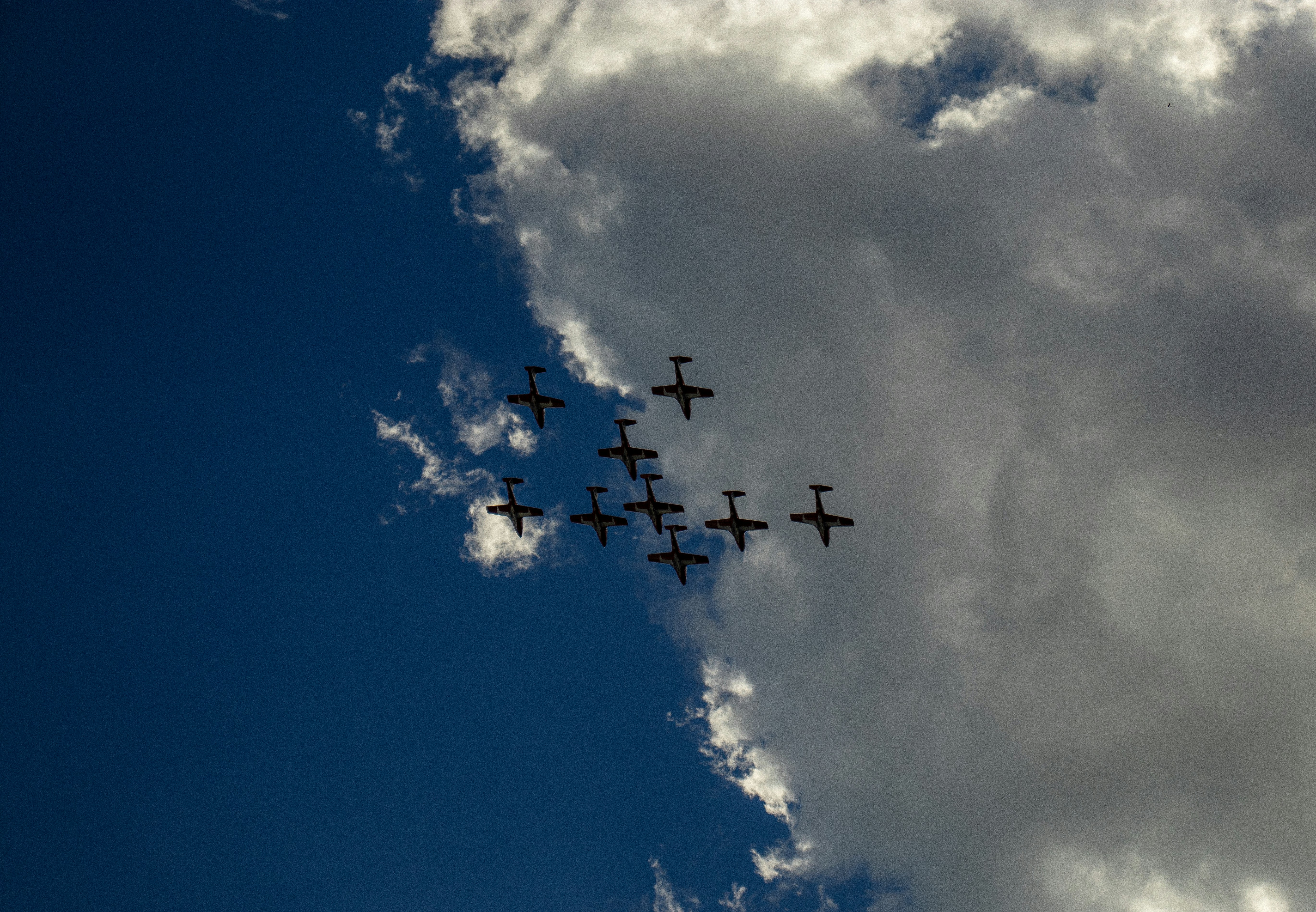 Formation of Silence: Nine Aircraft in a Skyward Pattern