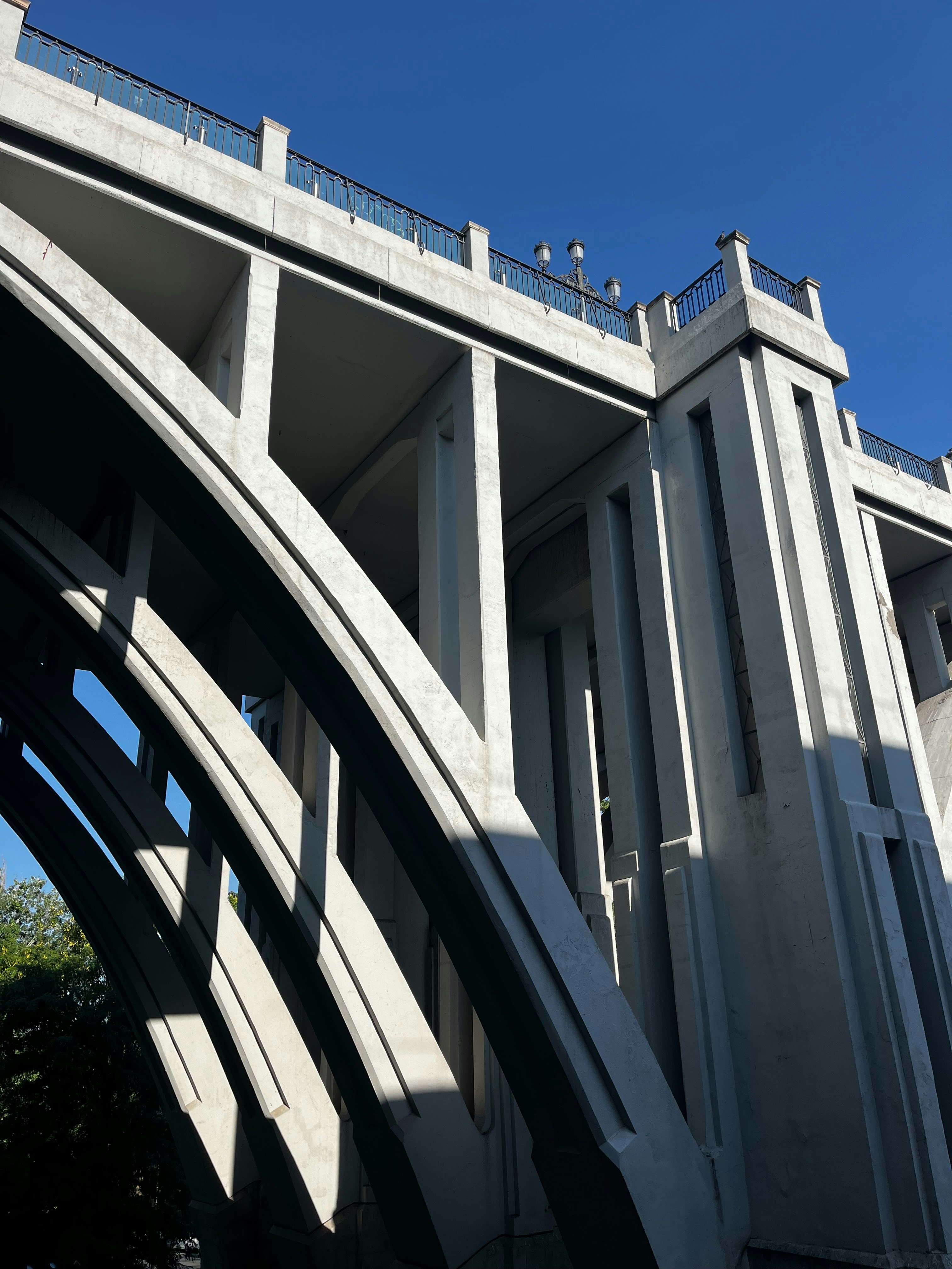 Concrete Arches Under a Clear Blue Arc—A Steady Angle on a Bridge