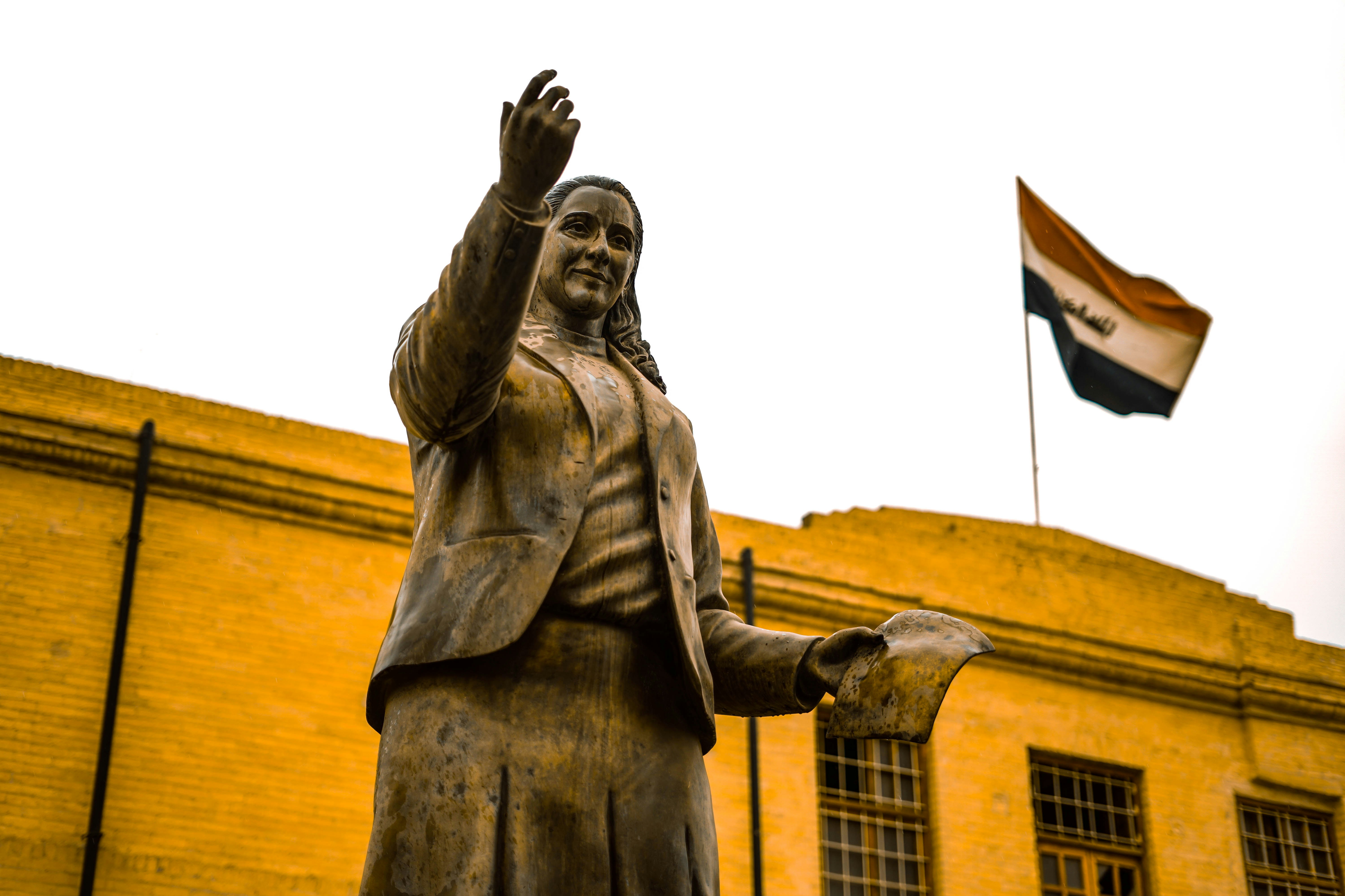 Raising Hands: A Bronze Leader Against a Golden Facade