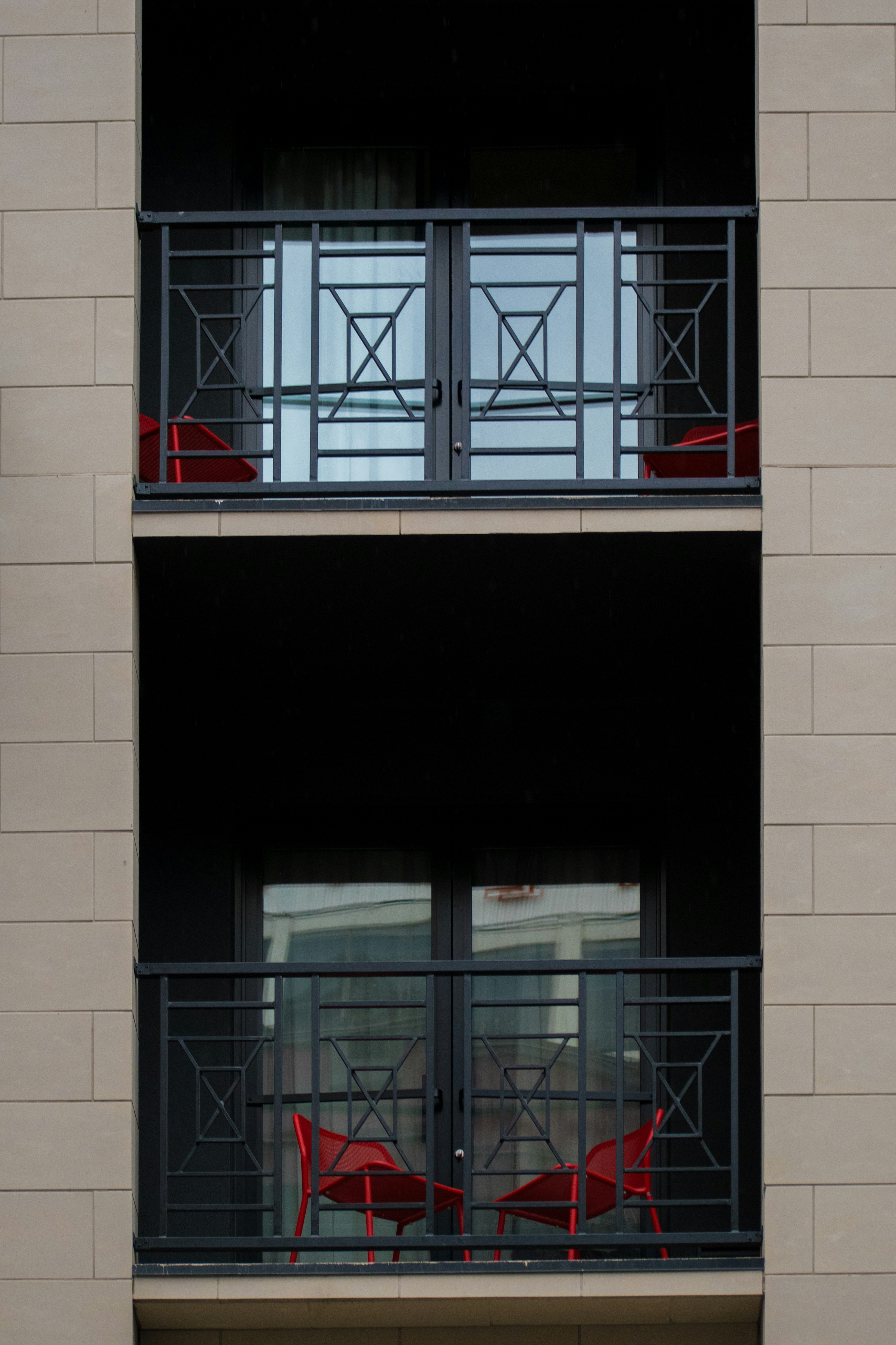Red chairs at a quiet balcony: symmetrical urban pause