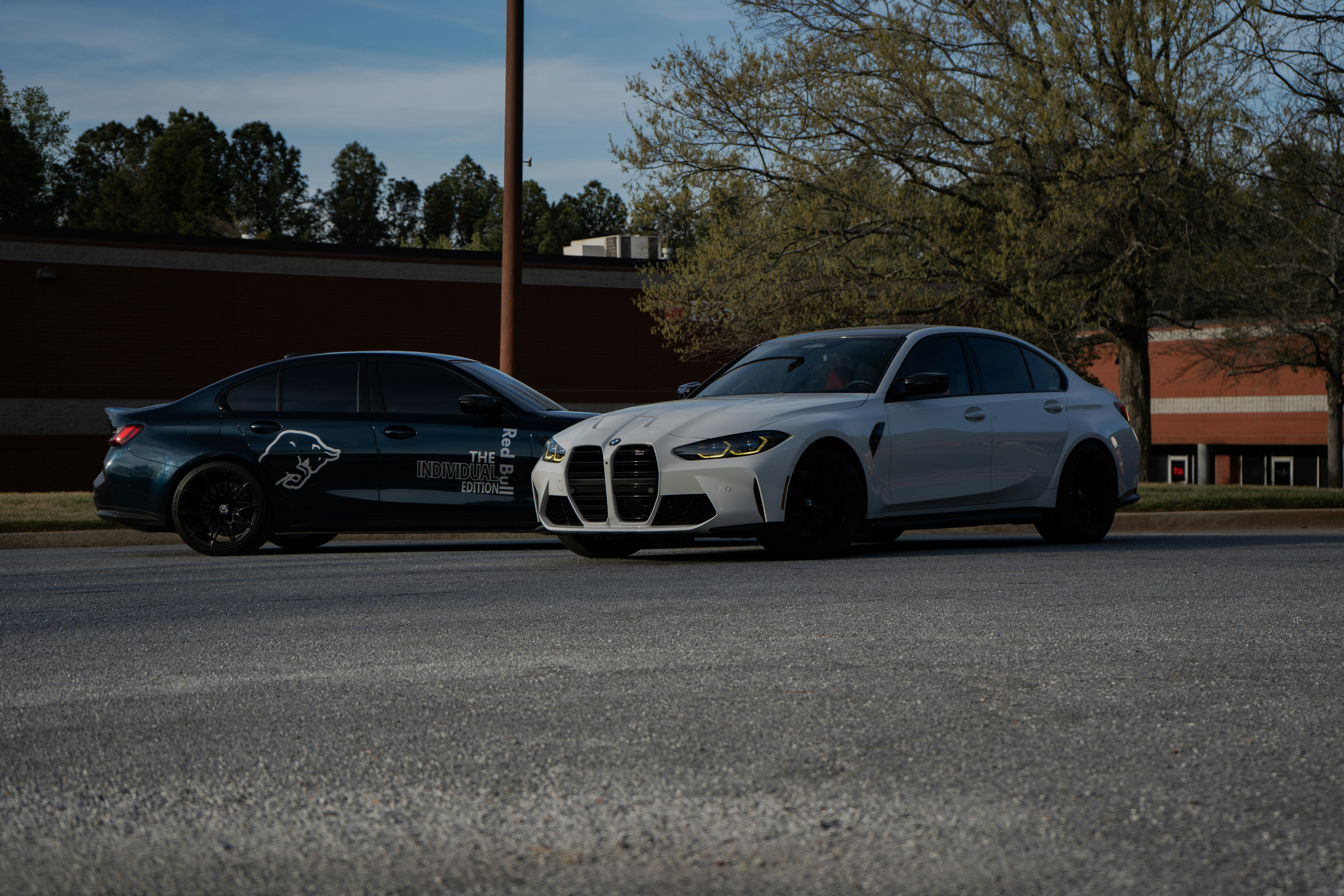 Two Cars in a Static Parking Lot: White BMW and Dark Sedan