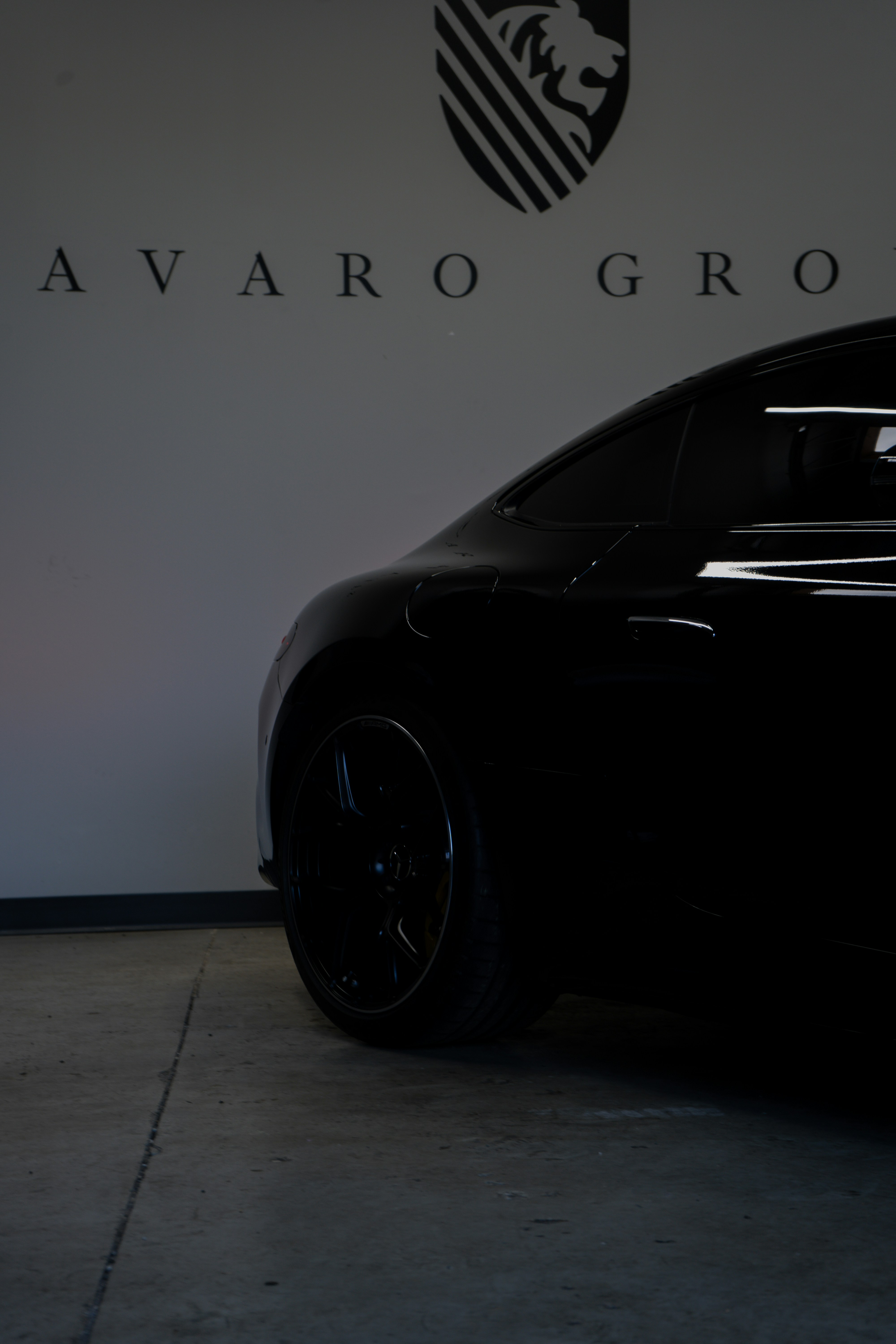 Black curvature: a Porsche silhouette under showroom glow