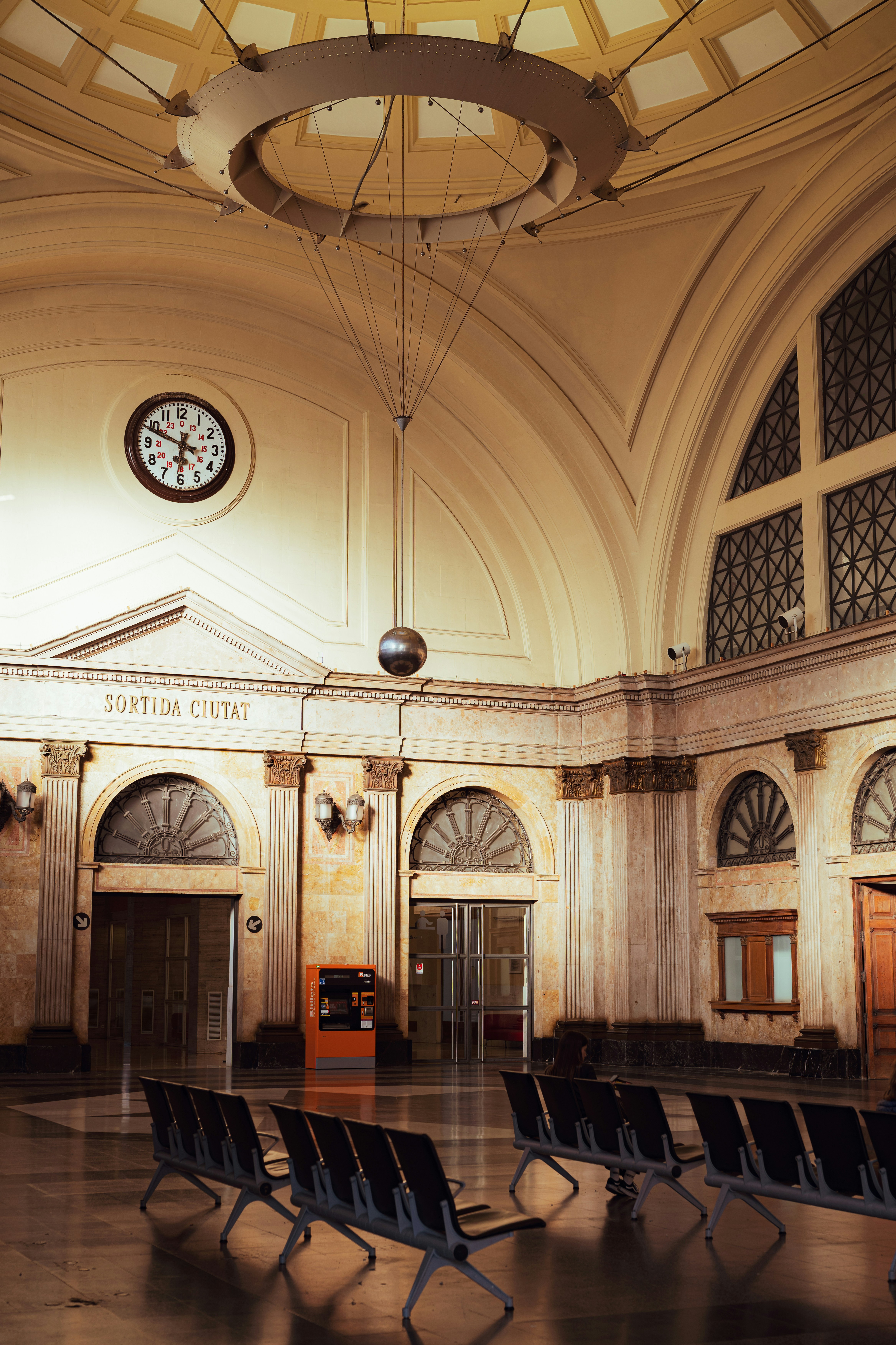 Grand Hallway at Dusk: Clock, Ring, and Waiting Seats