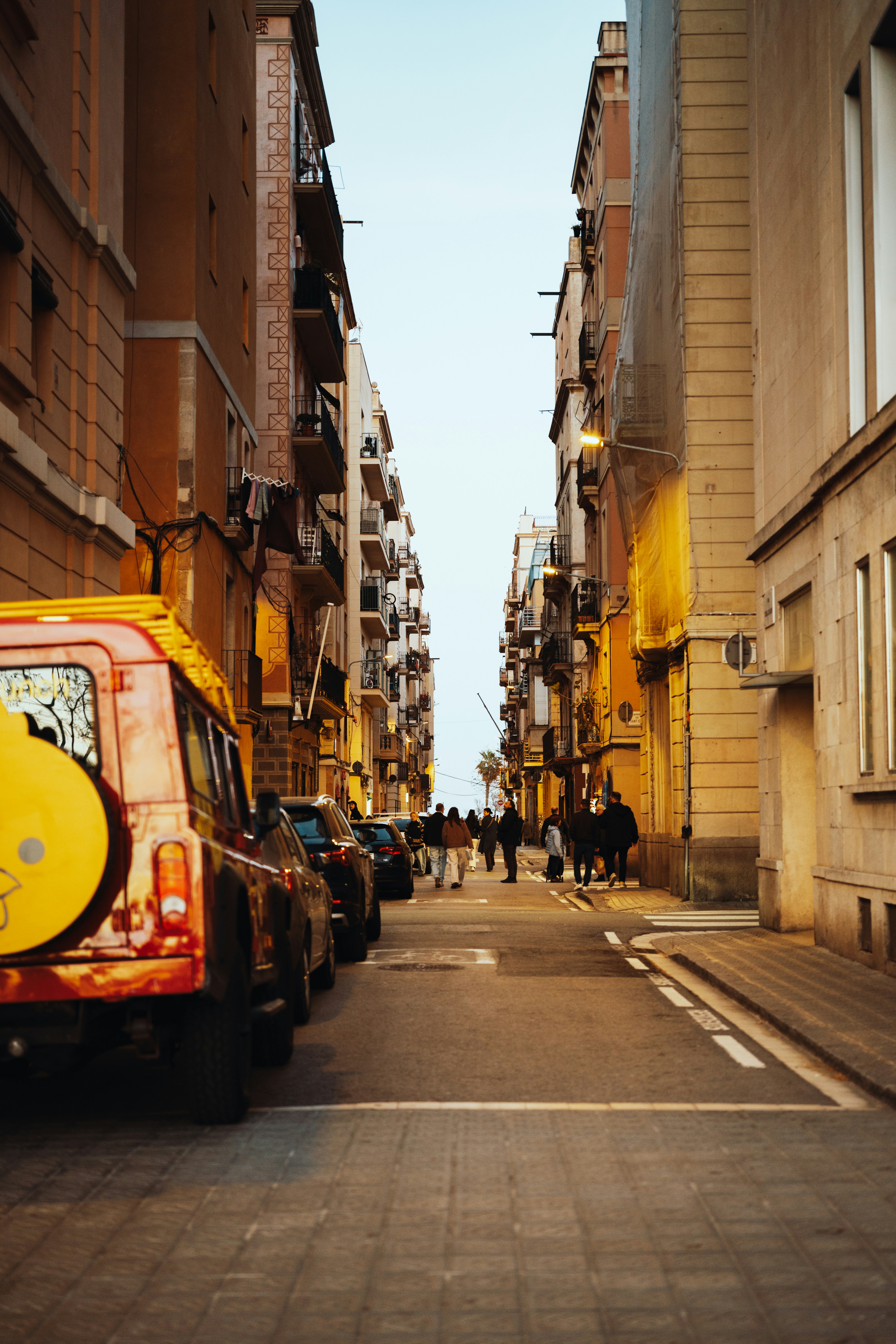Urban Corridor: People Converge Between Warm-Trimmed Buildings