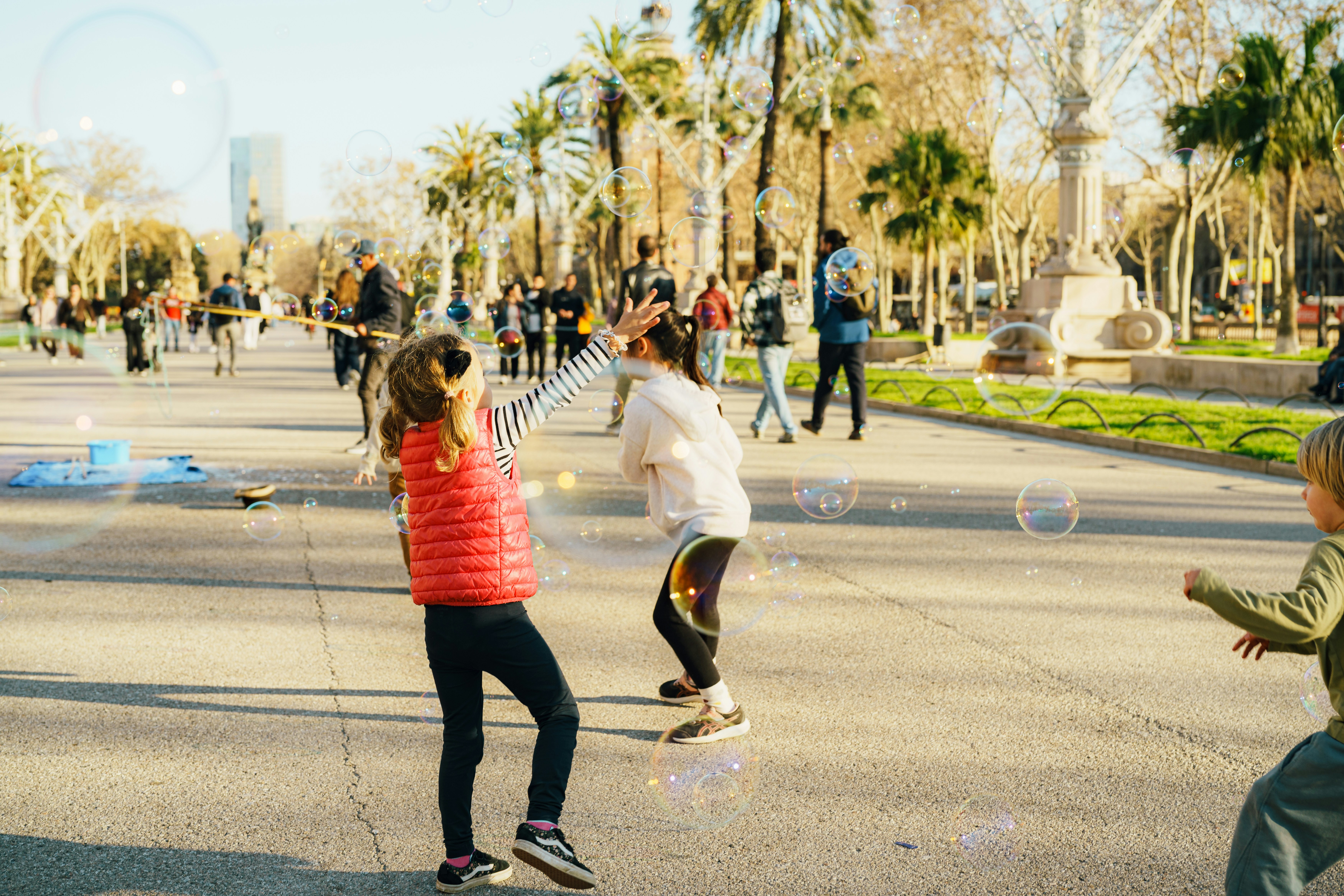 Joyful Freeze-Frame: Kids Chase Bubbles in a Sunlit Park