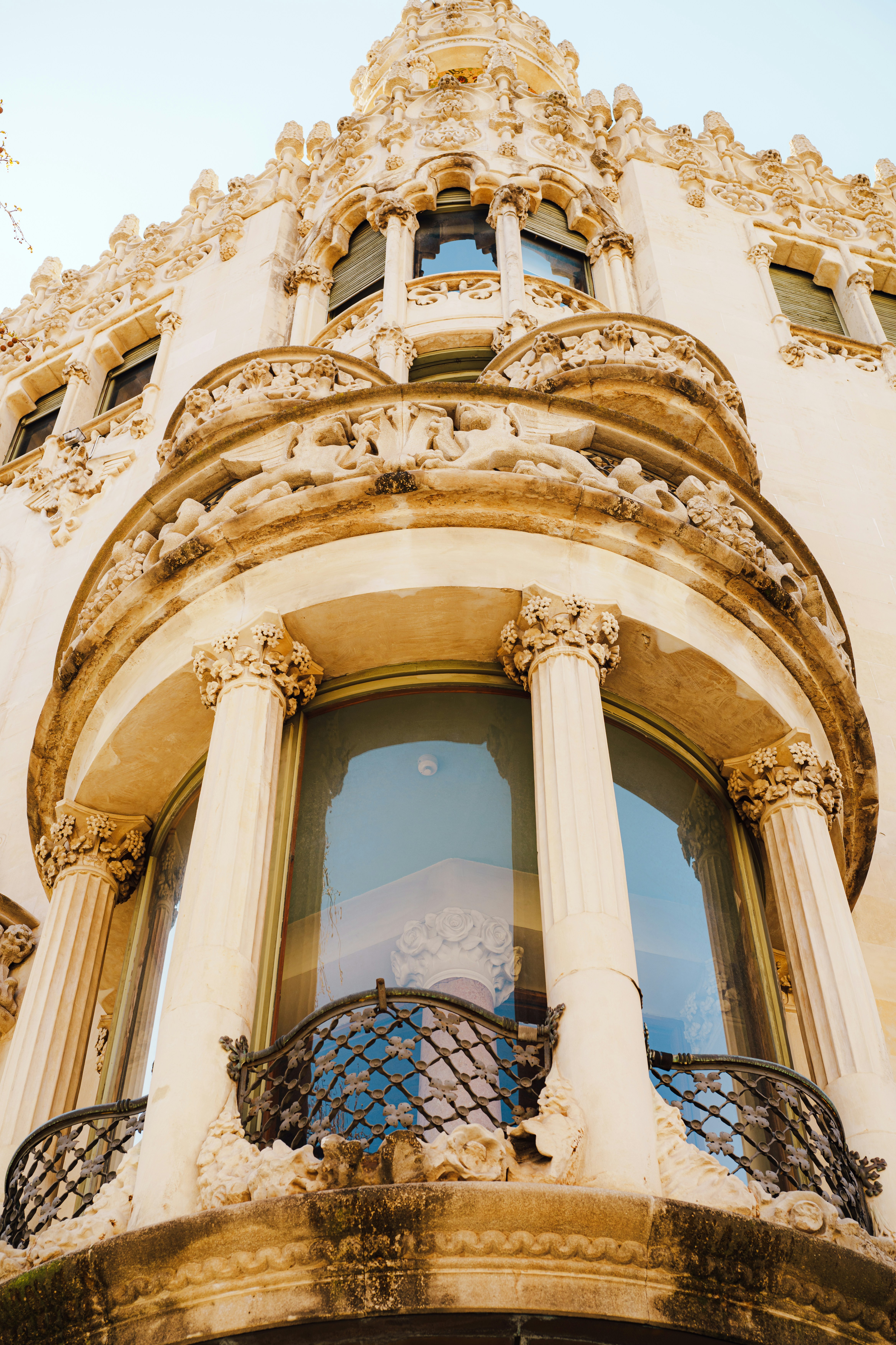Ornate Facade of a Sunlit Historic Building with Fluted Columns and Balcony