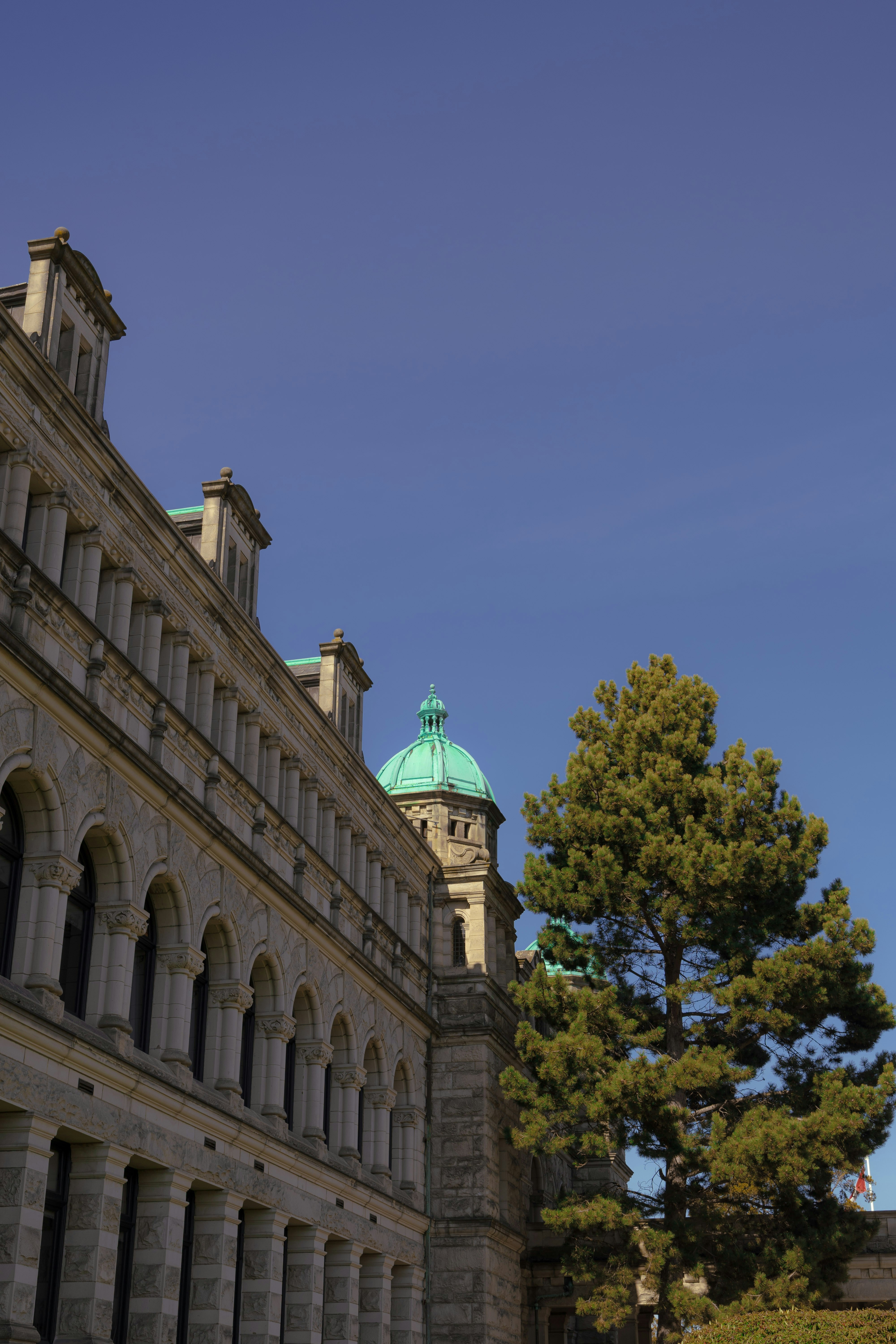Green Dome Over Stone Arches: A Classical Campus Facade Under a Clear Sky
