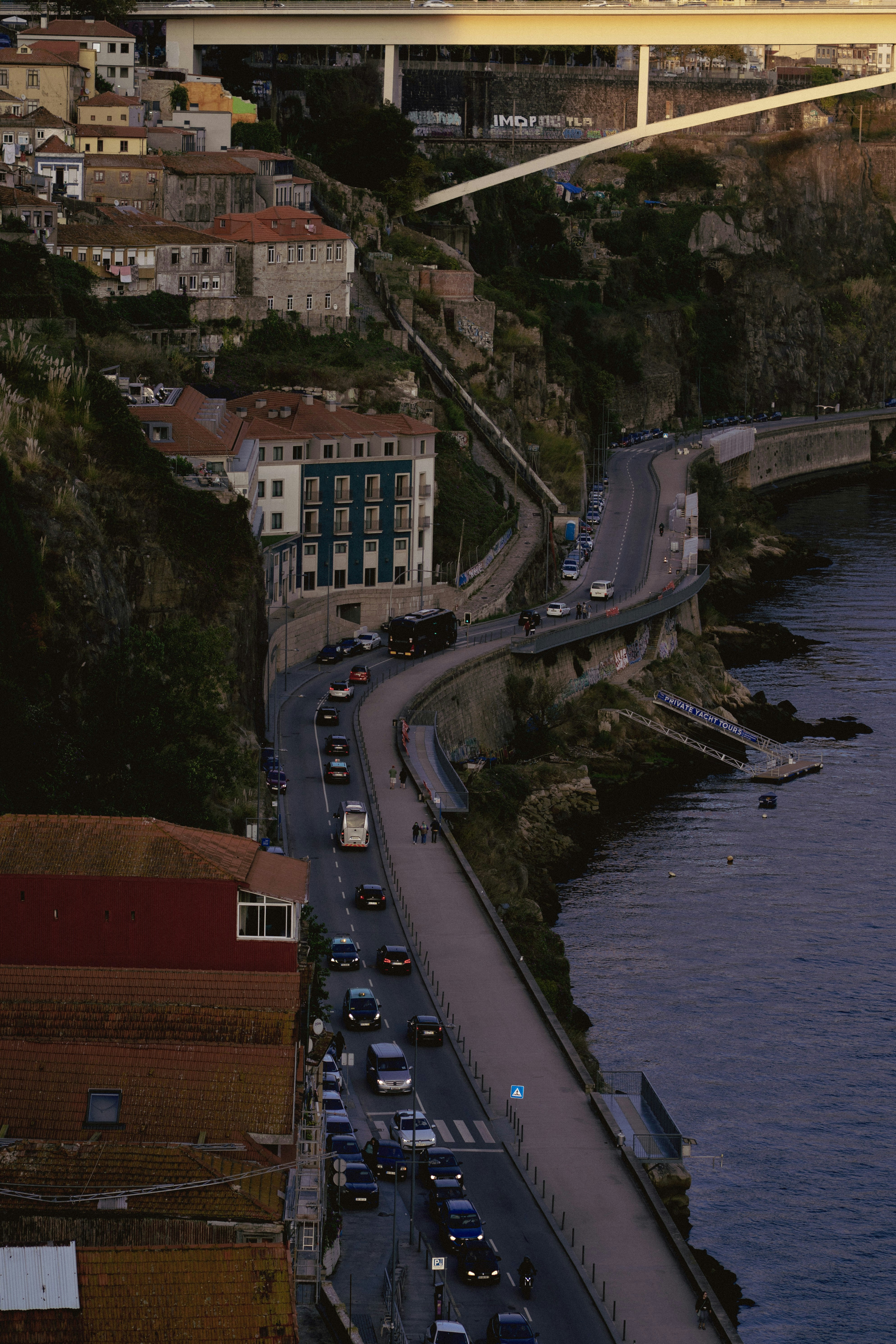 Coastal Climb: A winding hillside road hugging the cliffside along the riverbank