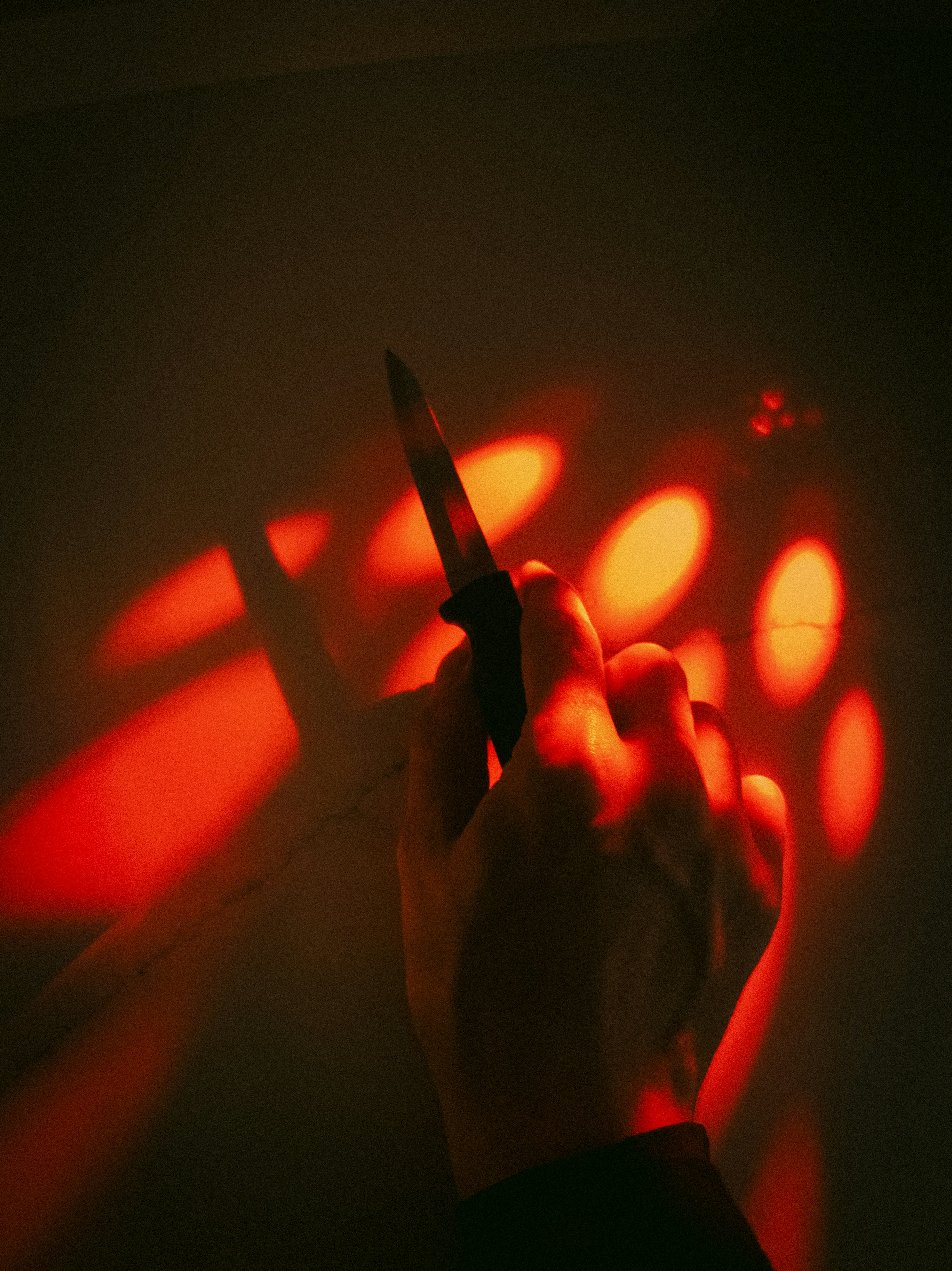 Crimson Precision: A Hand, a Knife, and a Halo of Light