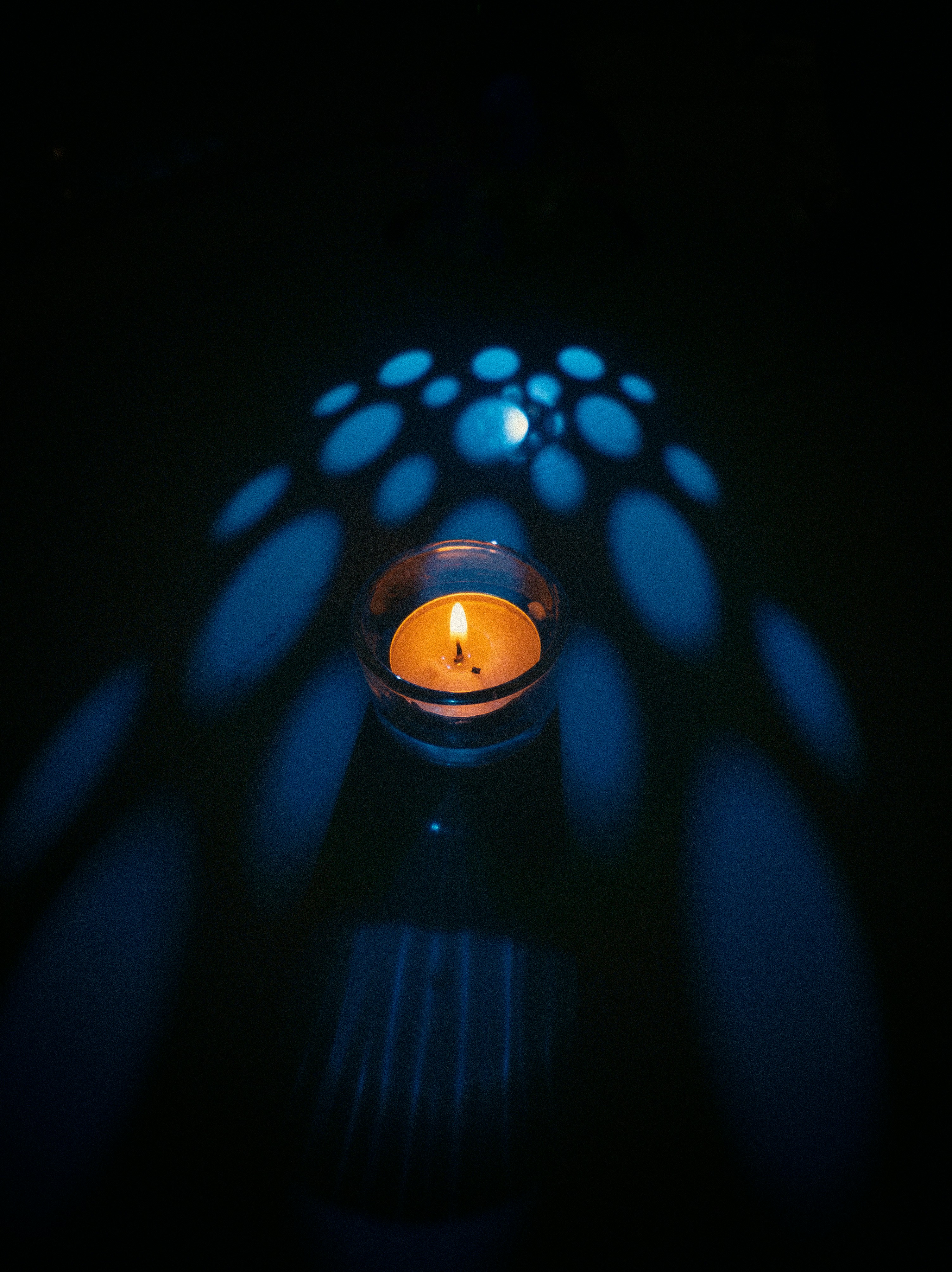 Illuminated Candle Between Blue Orbs