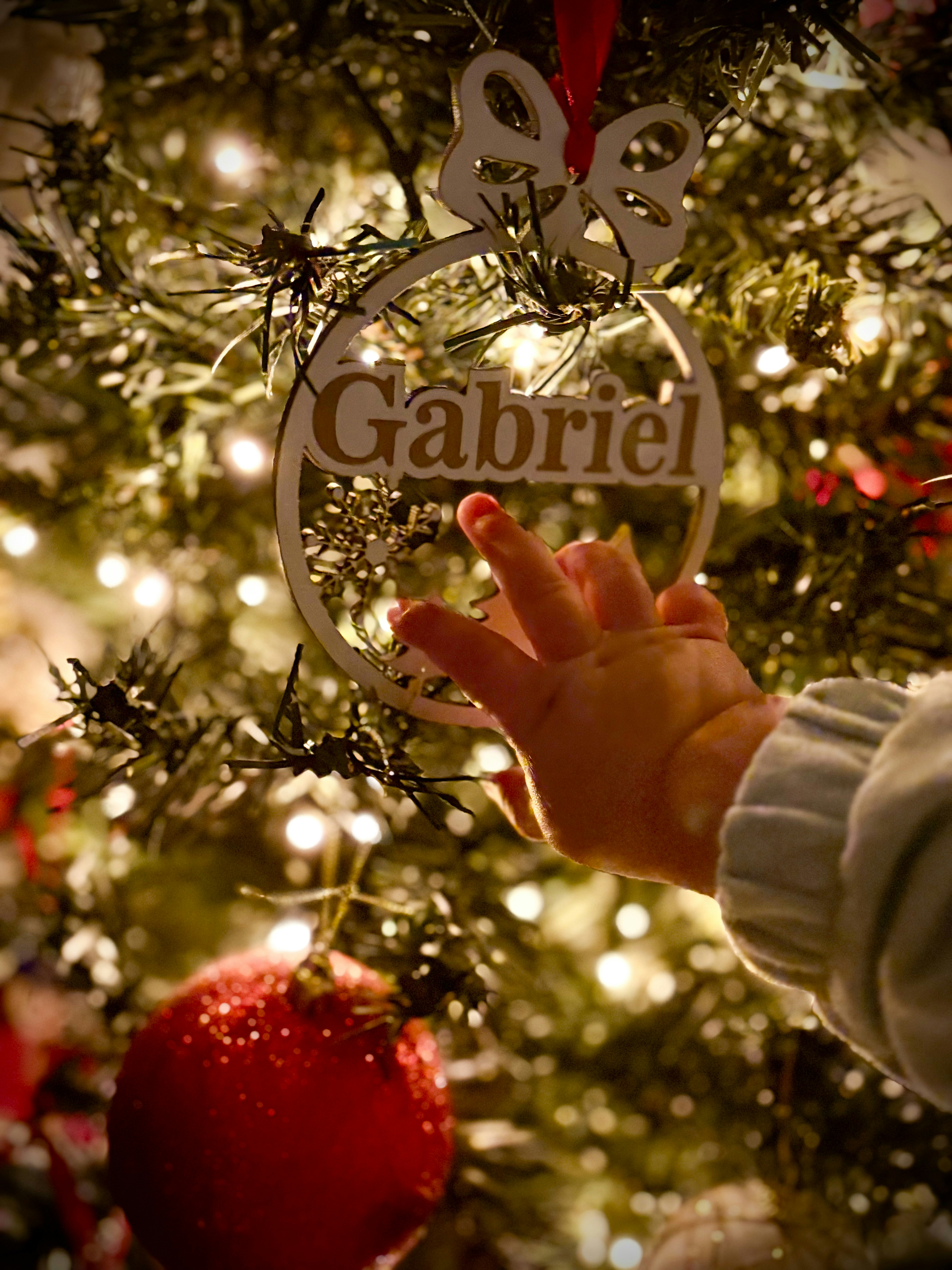 Name of Gabriel: a glowing ornament nudging toward a tiny hand