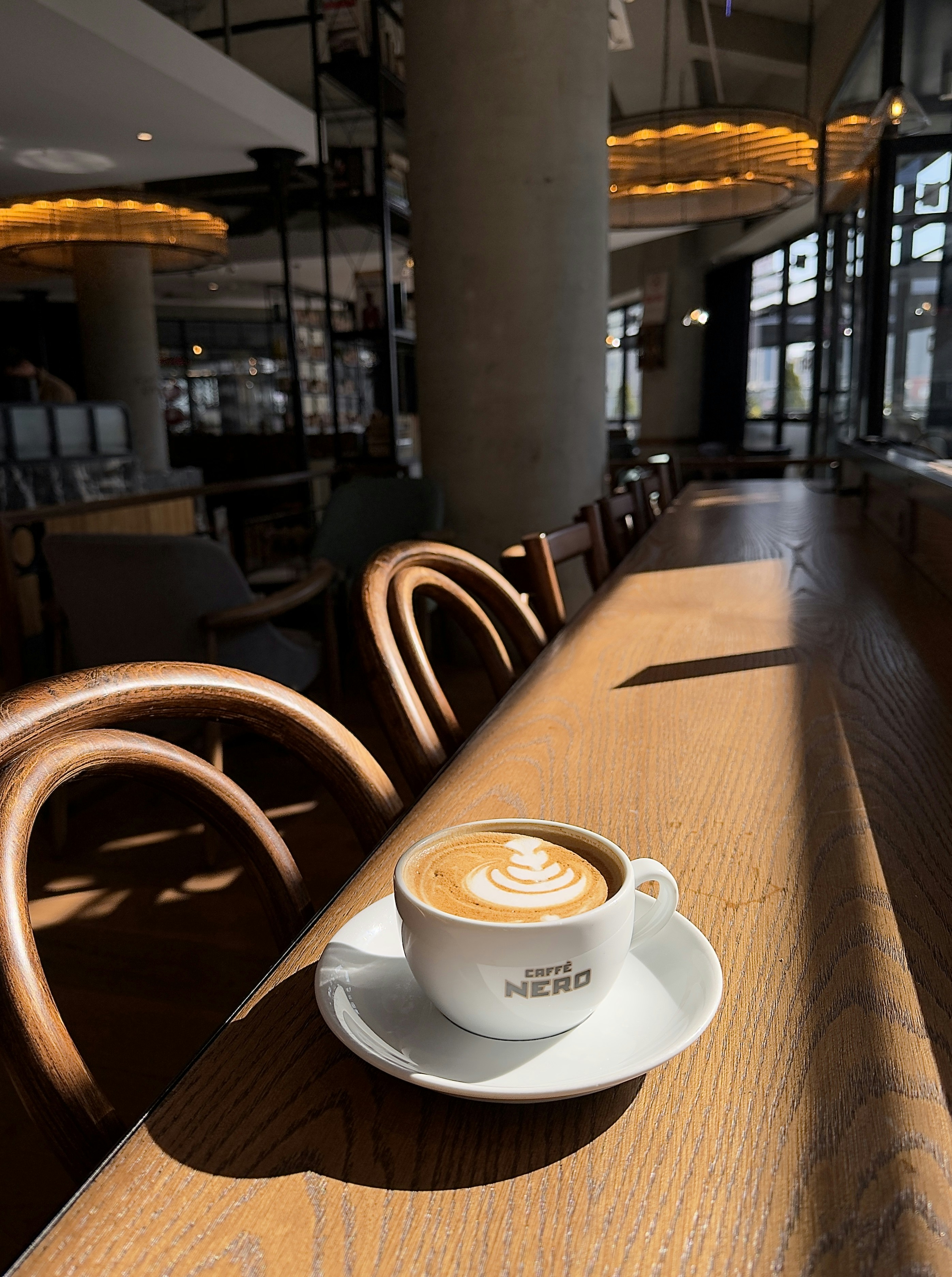 Single Cup, Long Shadow: Latte on the Sunlit Bar