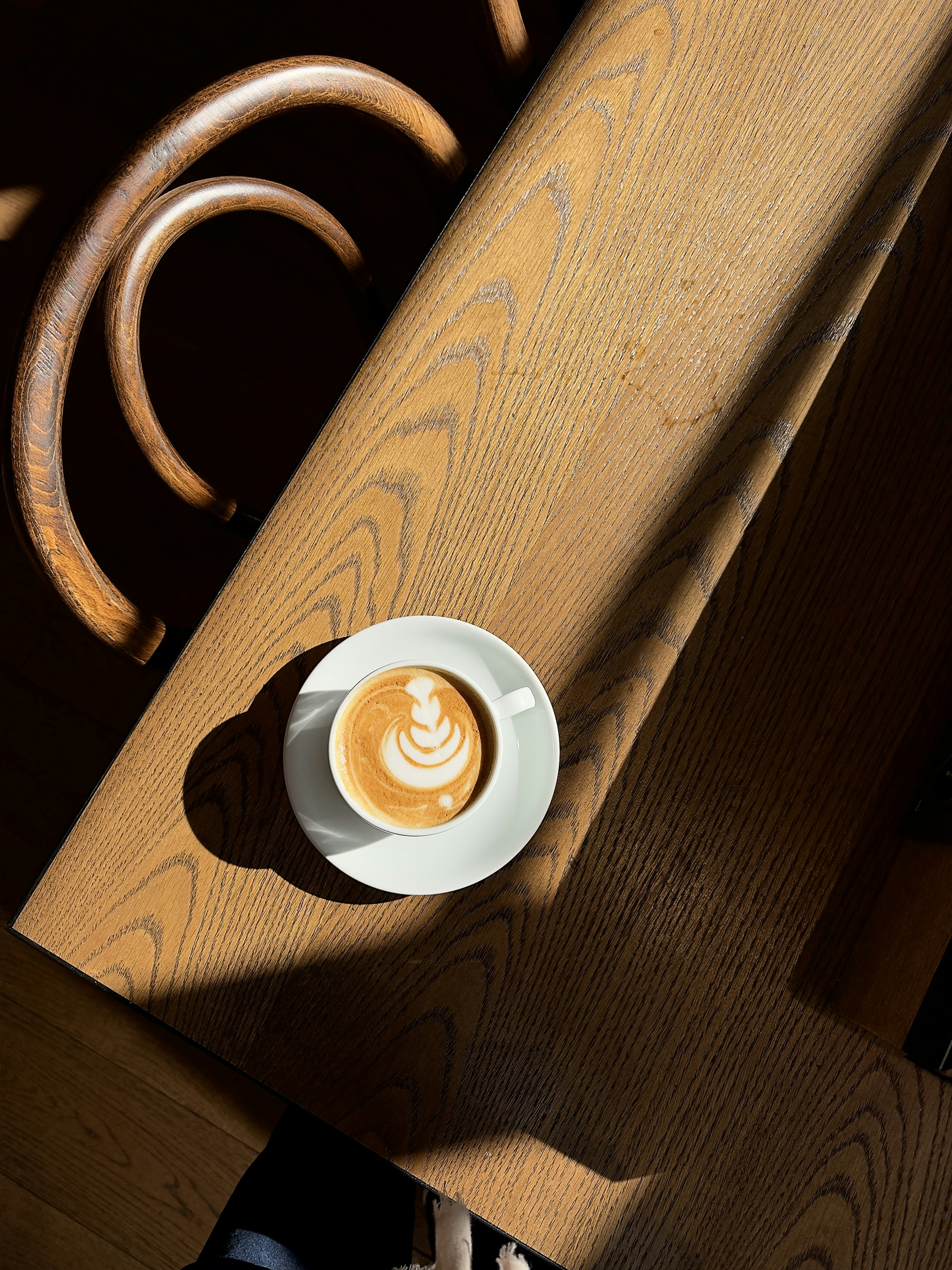 Cup of crema on sunlit wooden table