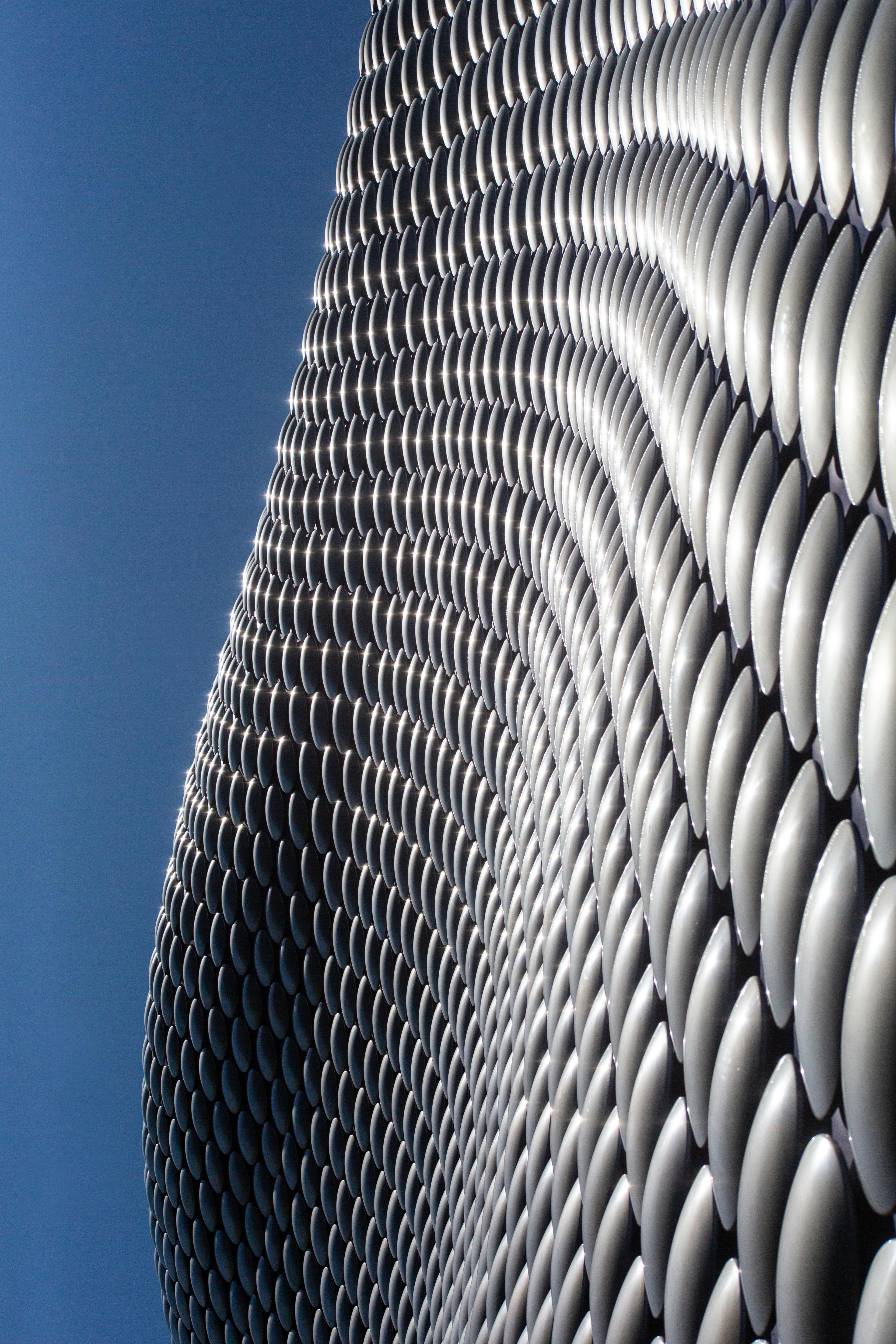 Metallic Concentric Waves on a Blue Sky Facade
