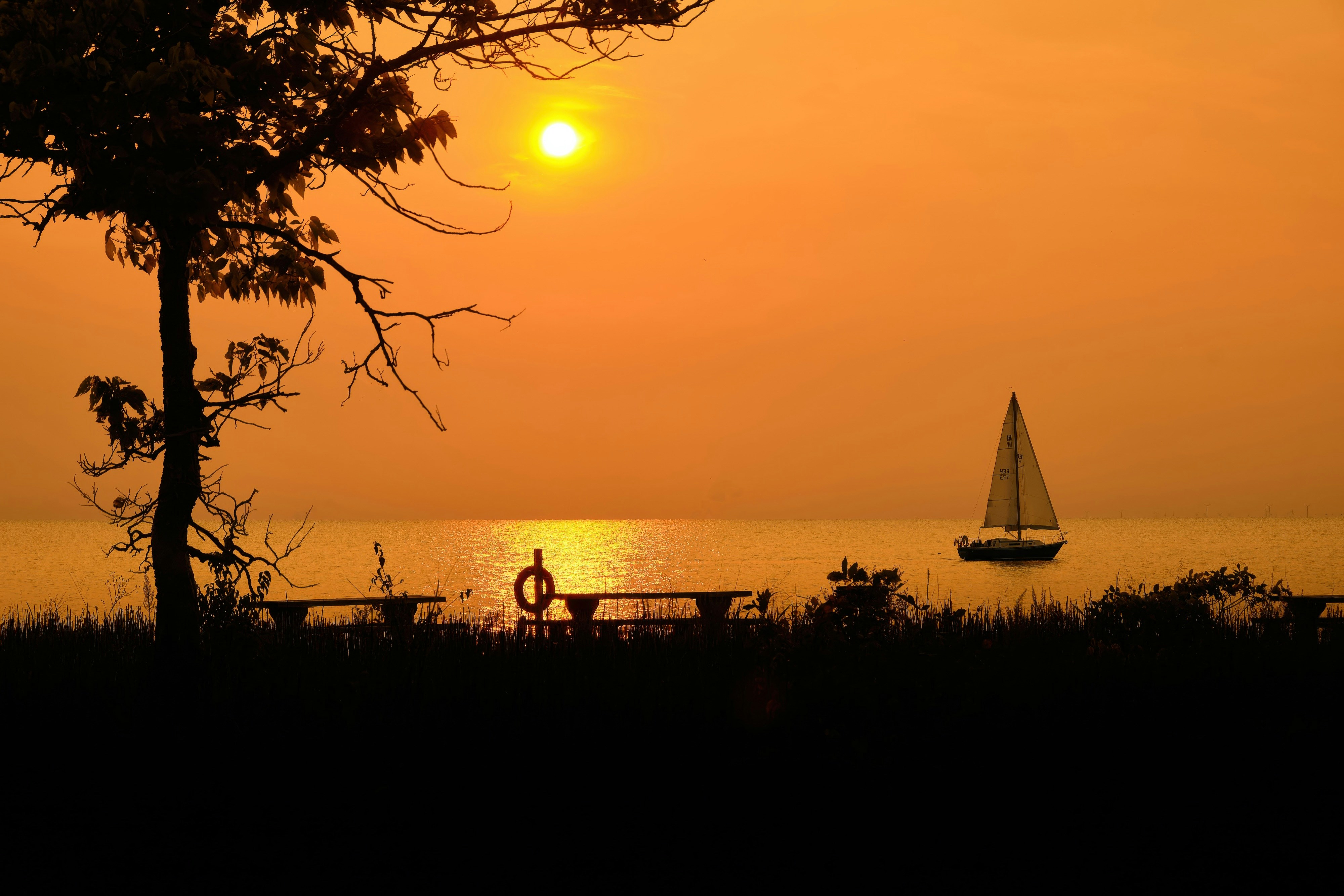 Sundown Silhouette over the Lake with Sailboat