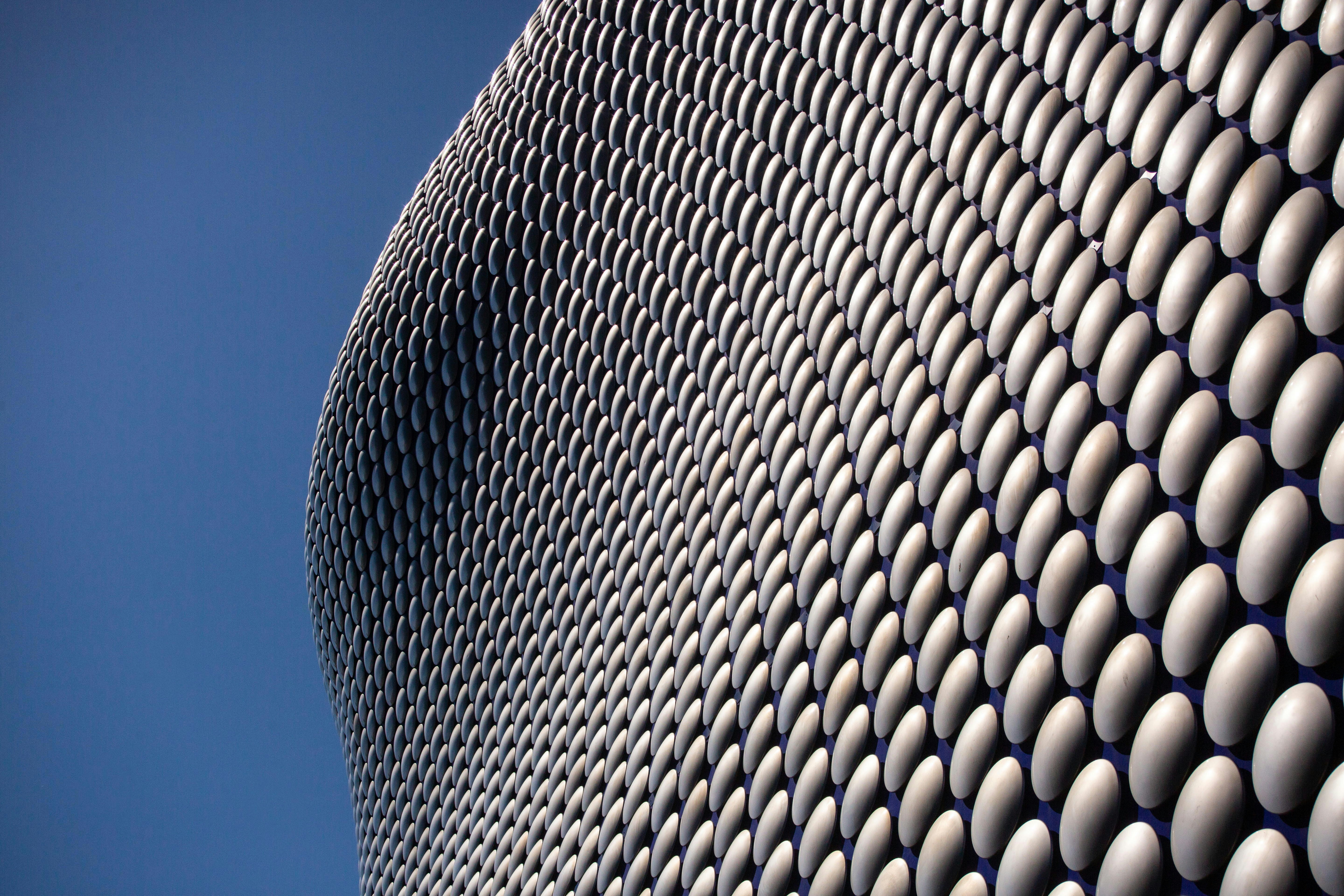 Architected Orbs: A Wave of Metallic Texture Under a Clear Sky