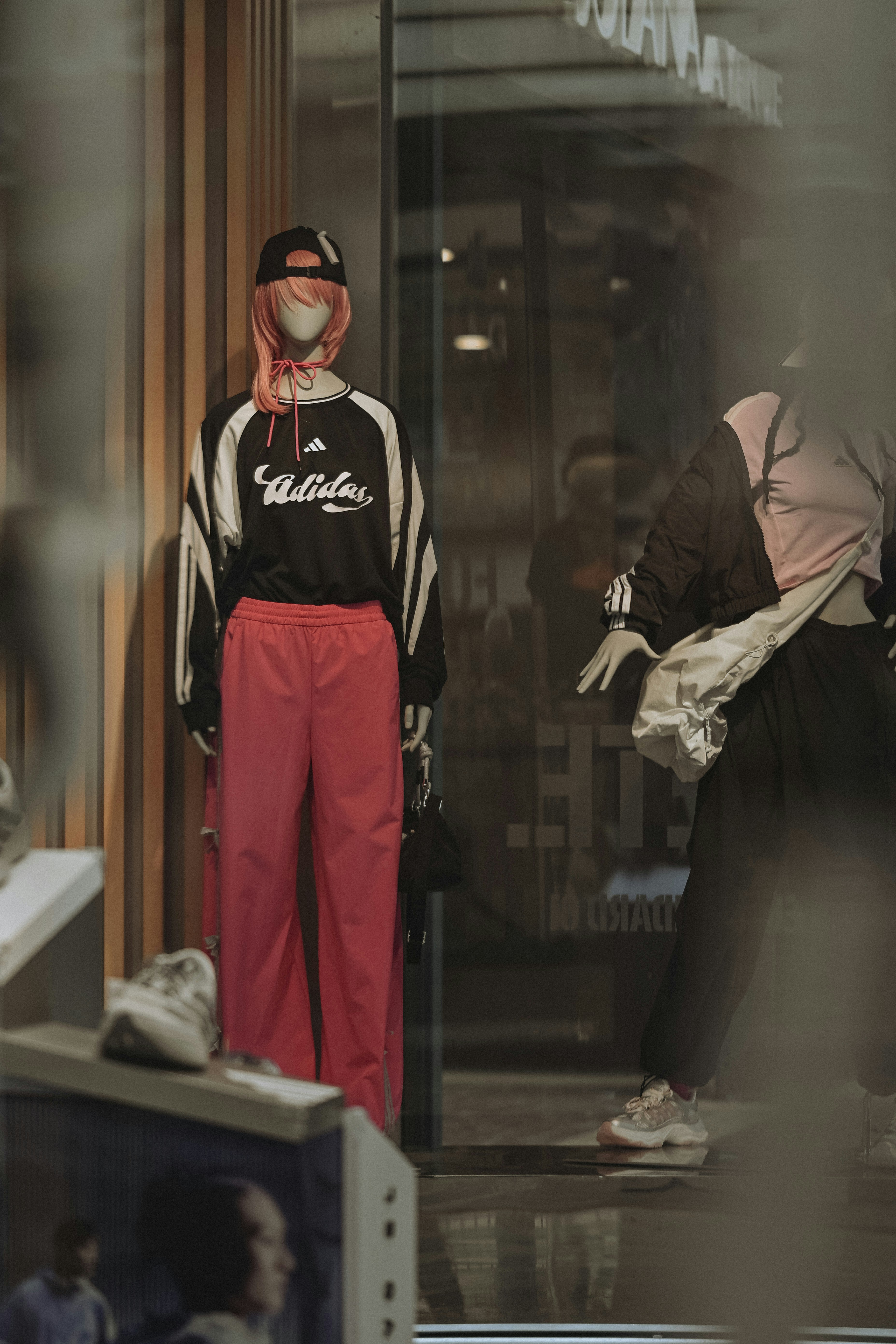 Masked mannequin in a storefront: streetwear mood and soft reflections