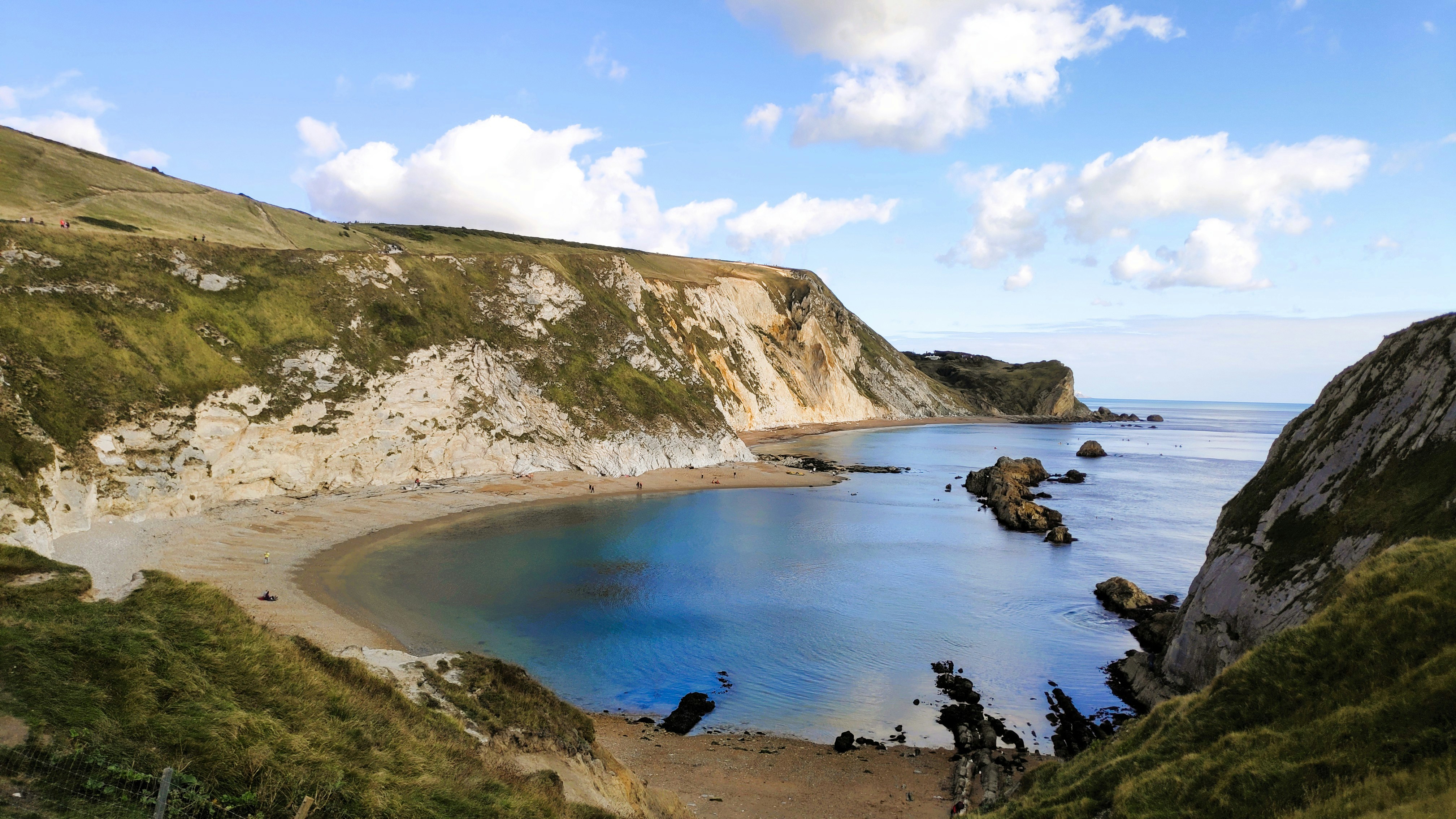 Cliffside Cove: Sunlit Beach Embraced by White Cliffs