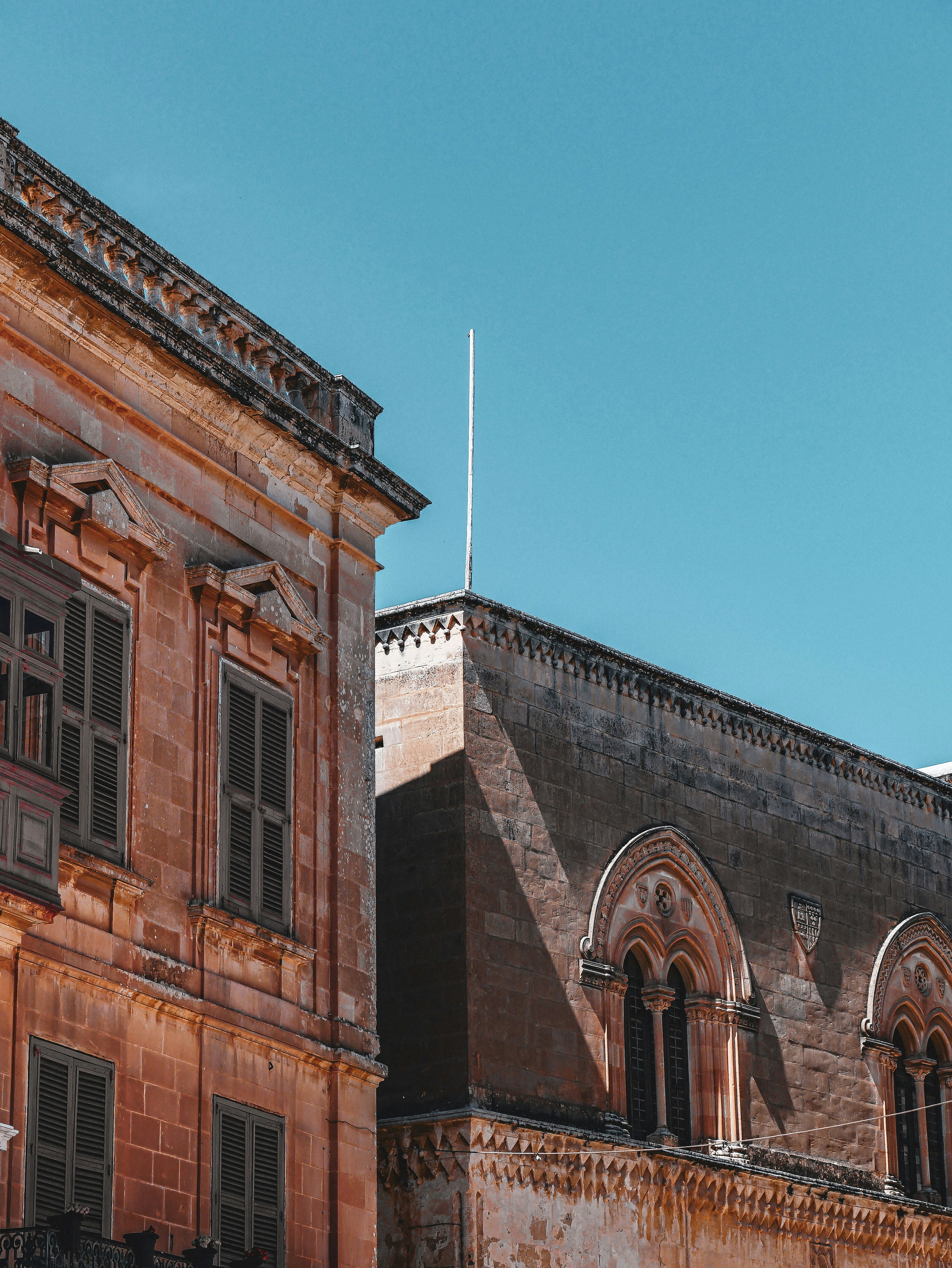 Two old buildings under a clear blue sky