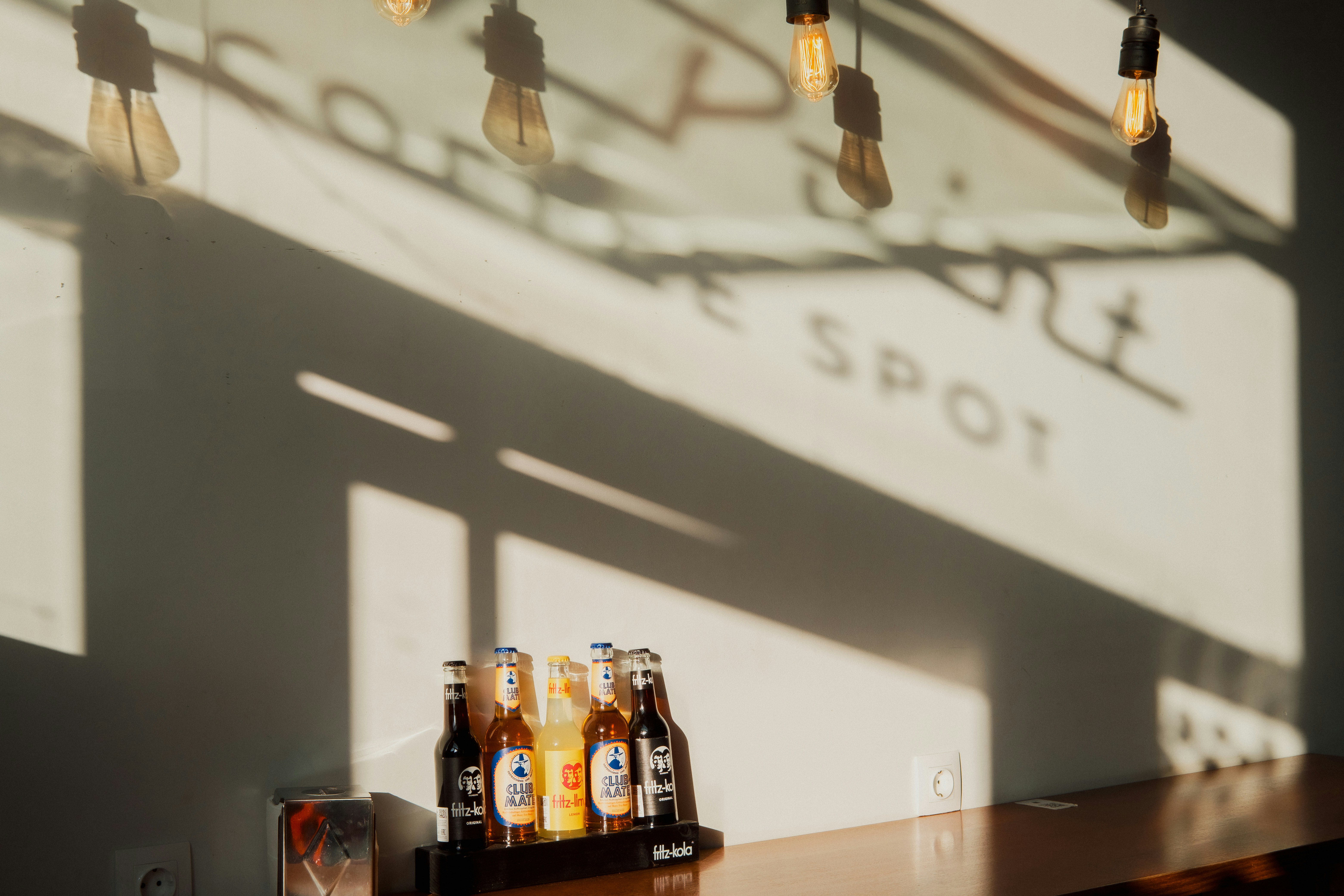 Backlit Bar Signage Casting Quiet Shadows over Bottles