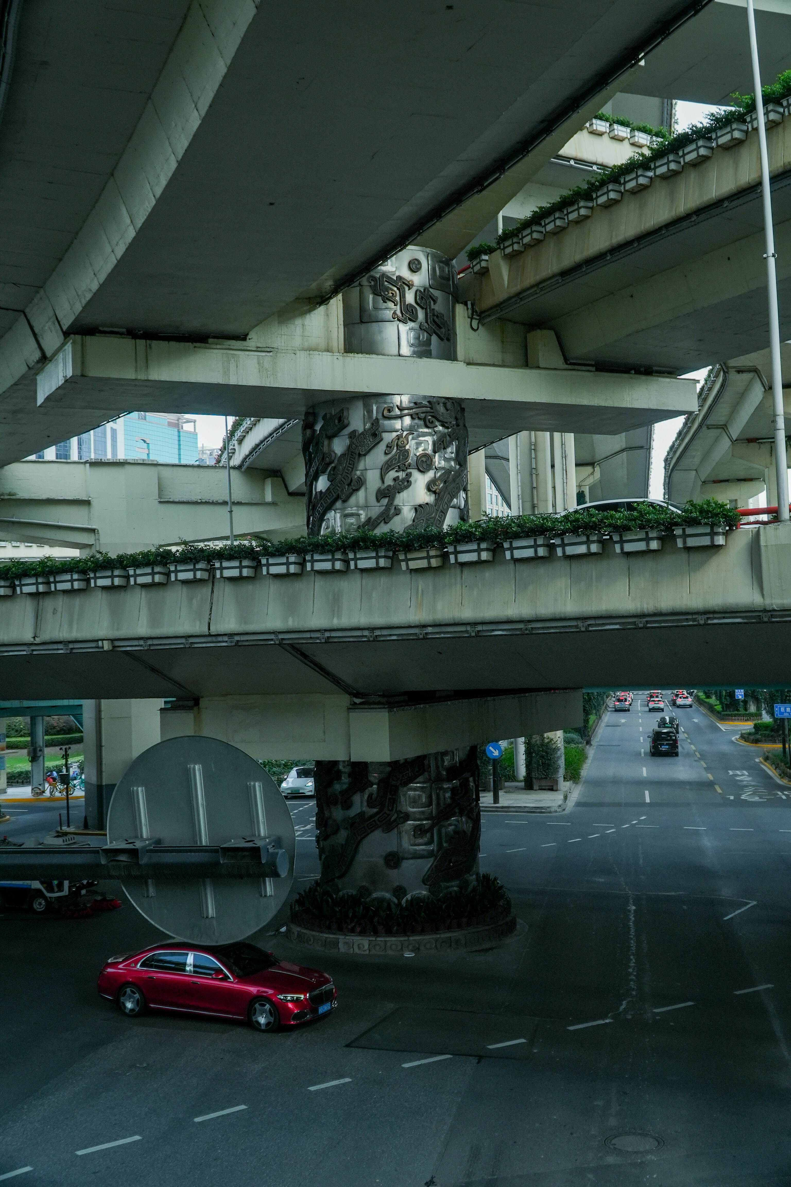 Underpass Sculpture Towers Above: Colorful Car Beneath Concrete Arches
