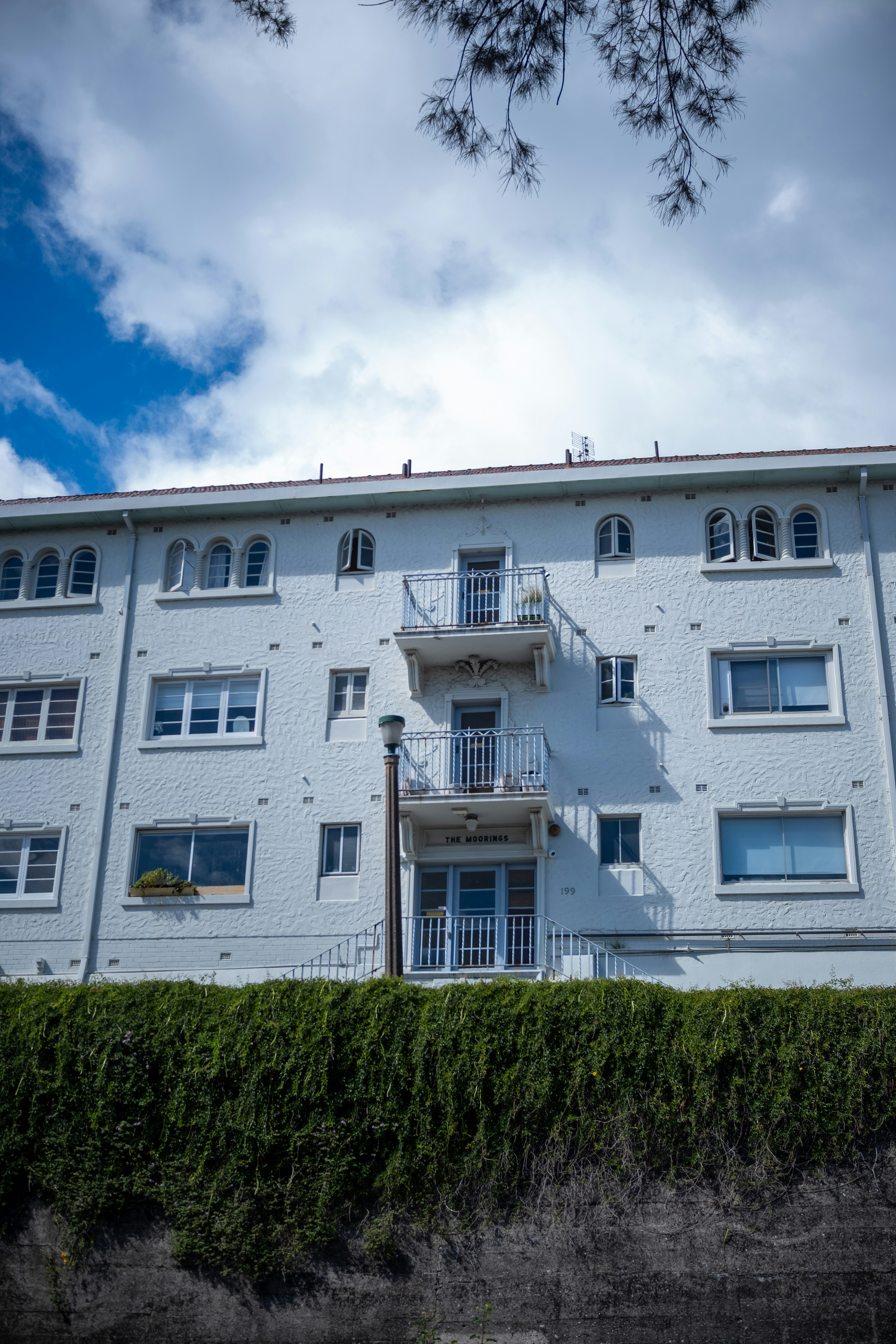 Balcony Facade Above a Hedge