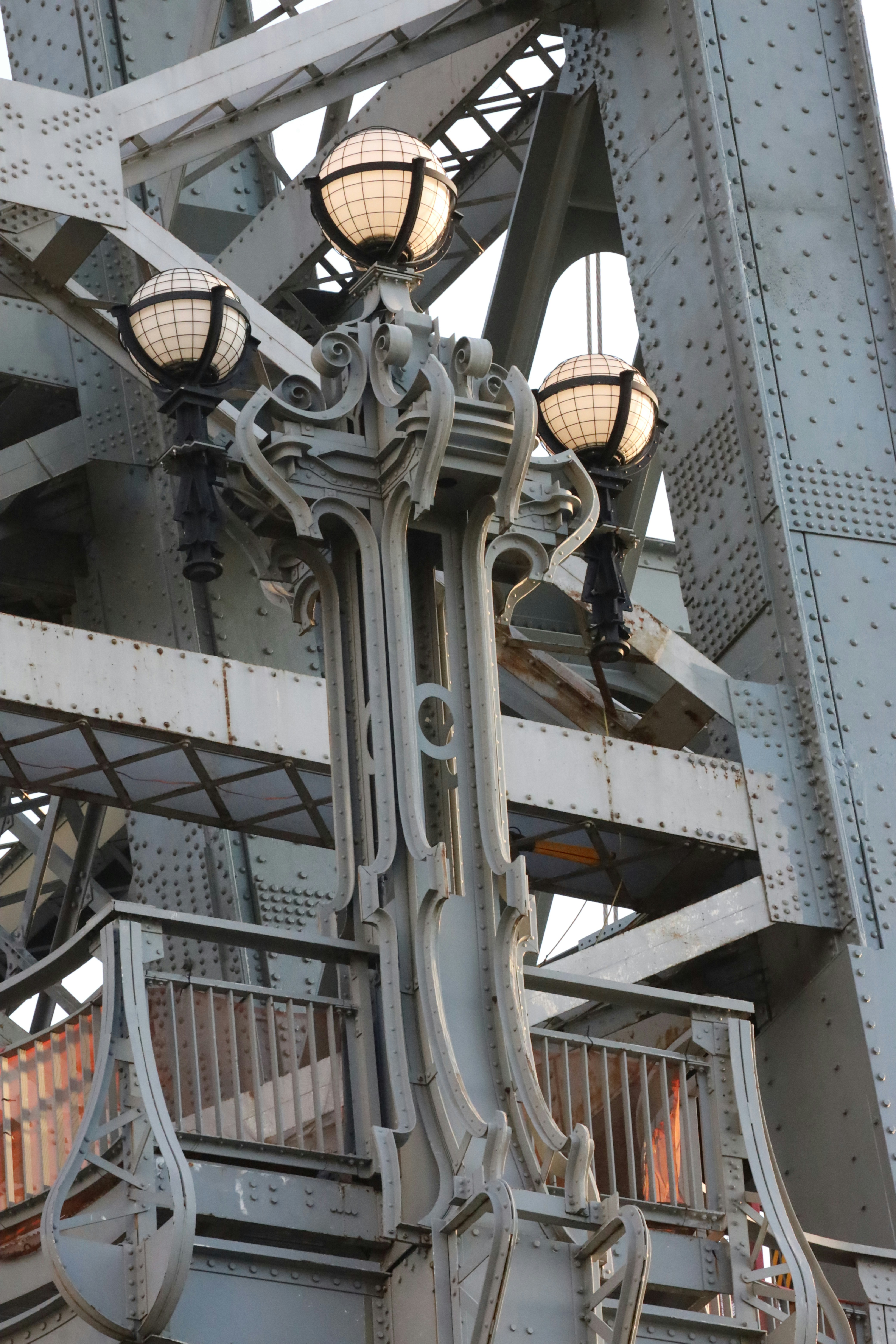 Ornate lamp post framed by steel ribs on a bridge