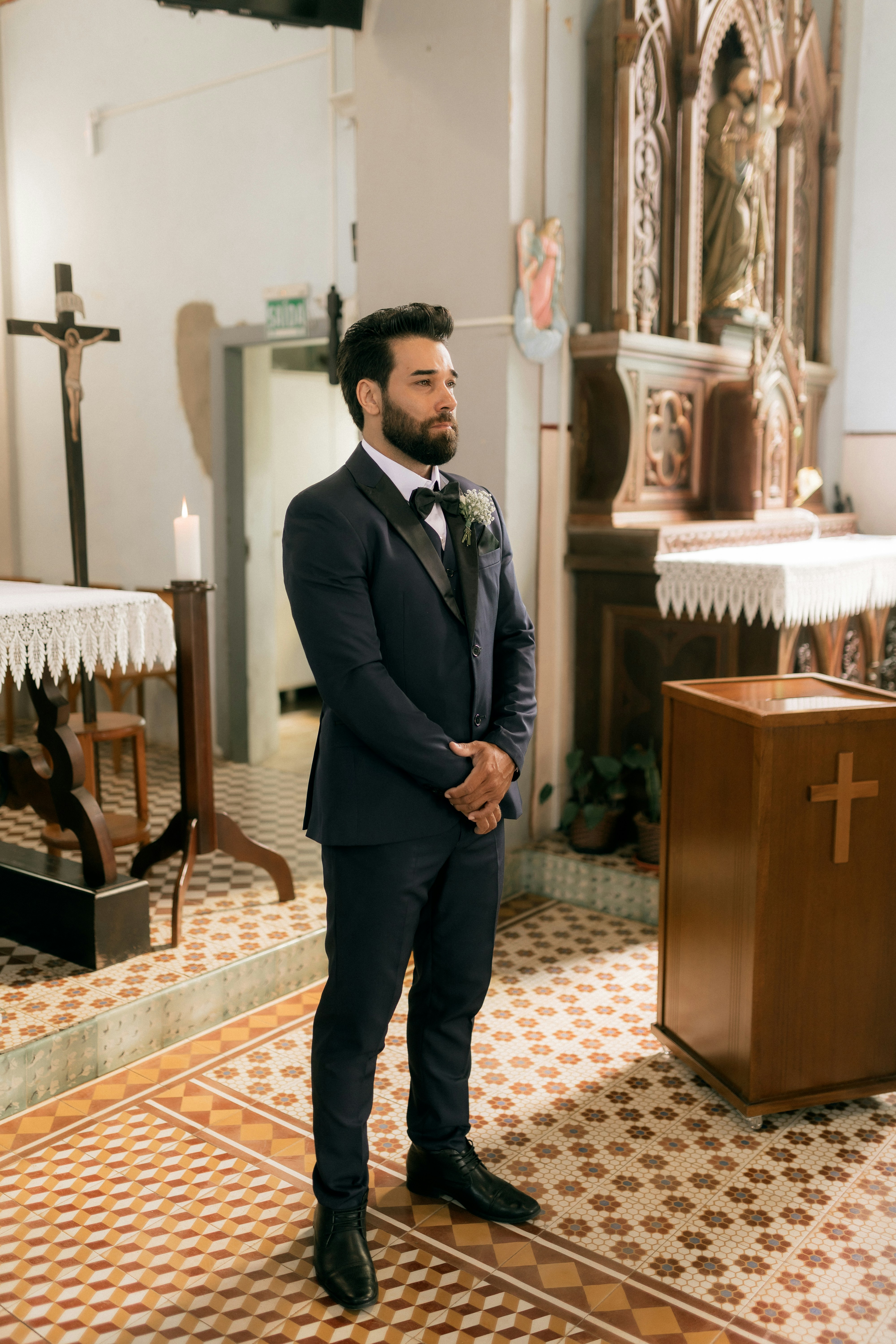 Groom in a church altar, poised in quiet anticipation