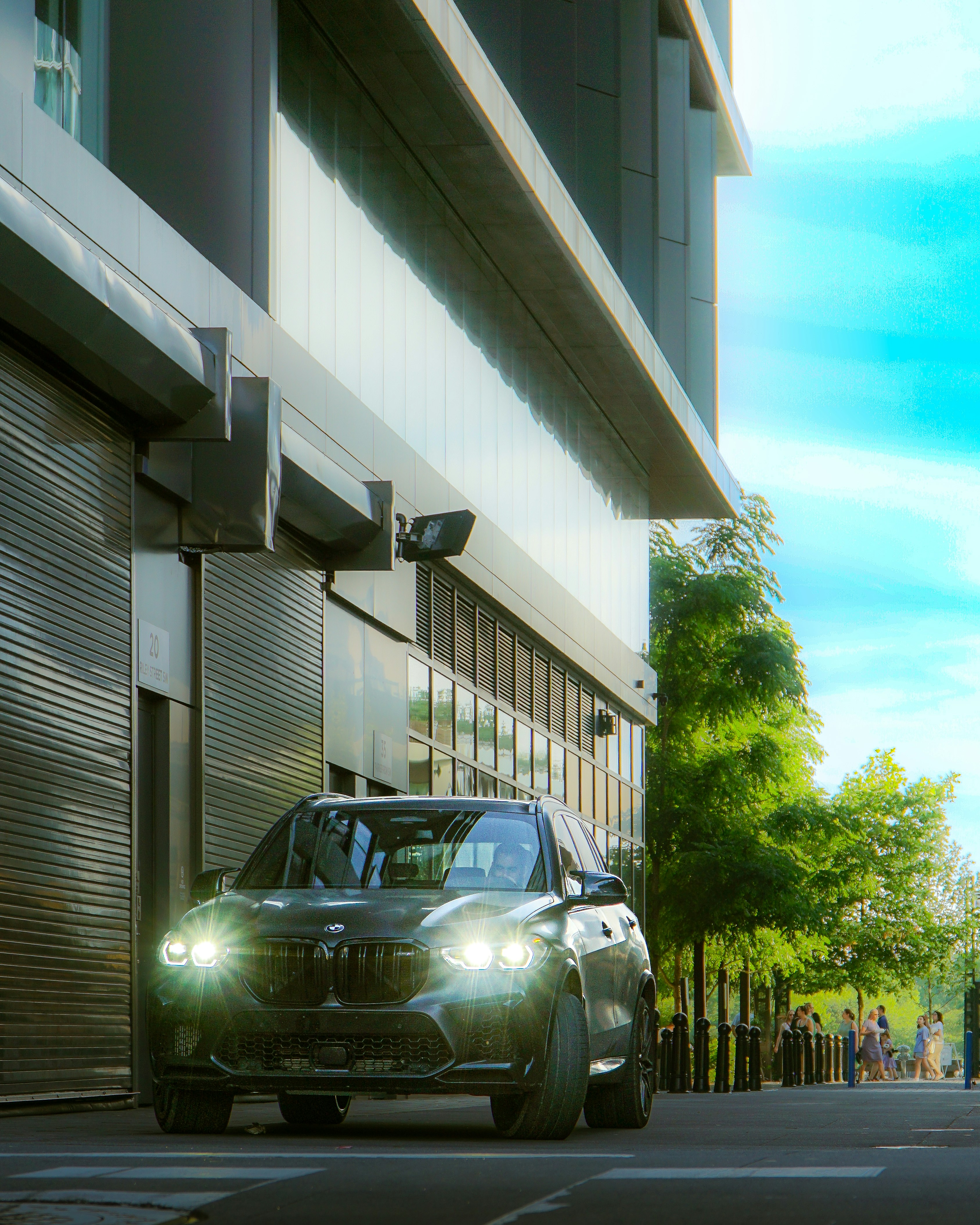 Urban Thoroughfare: Sunlit BMW Emerging from the Street Corridor