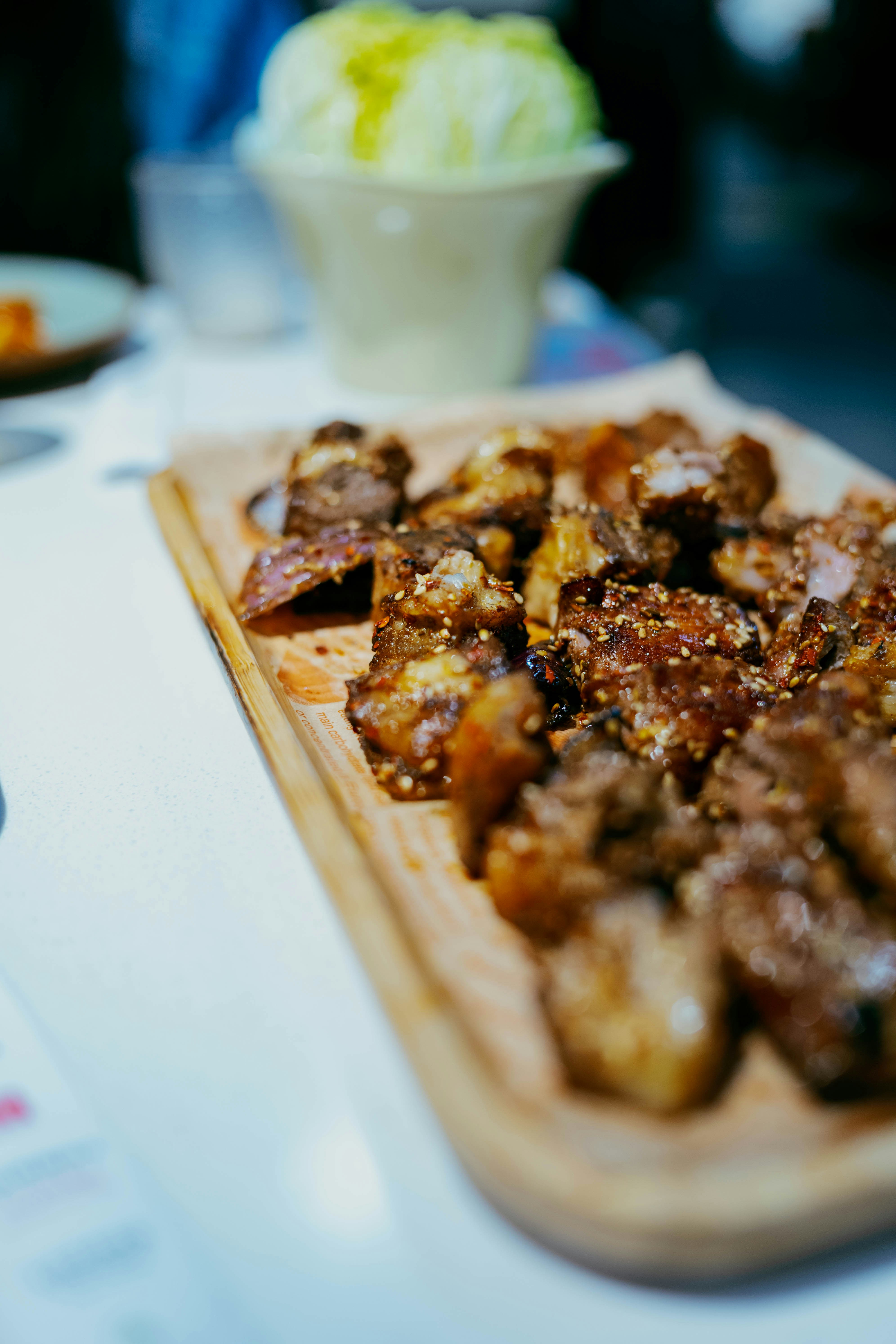 Charred Tenderness: A Wooden Tray of Glazed Bites
