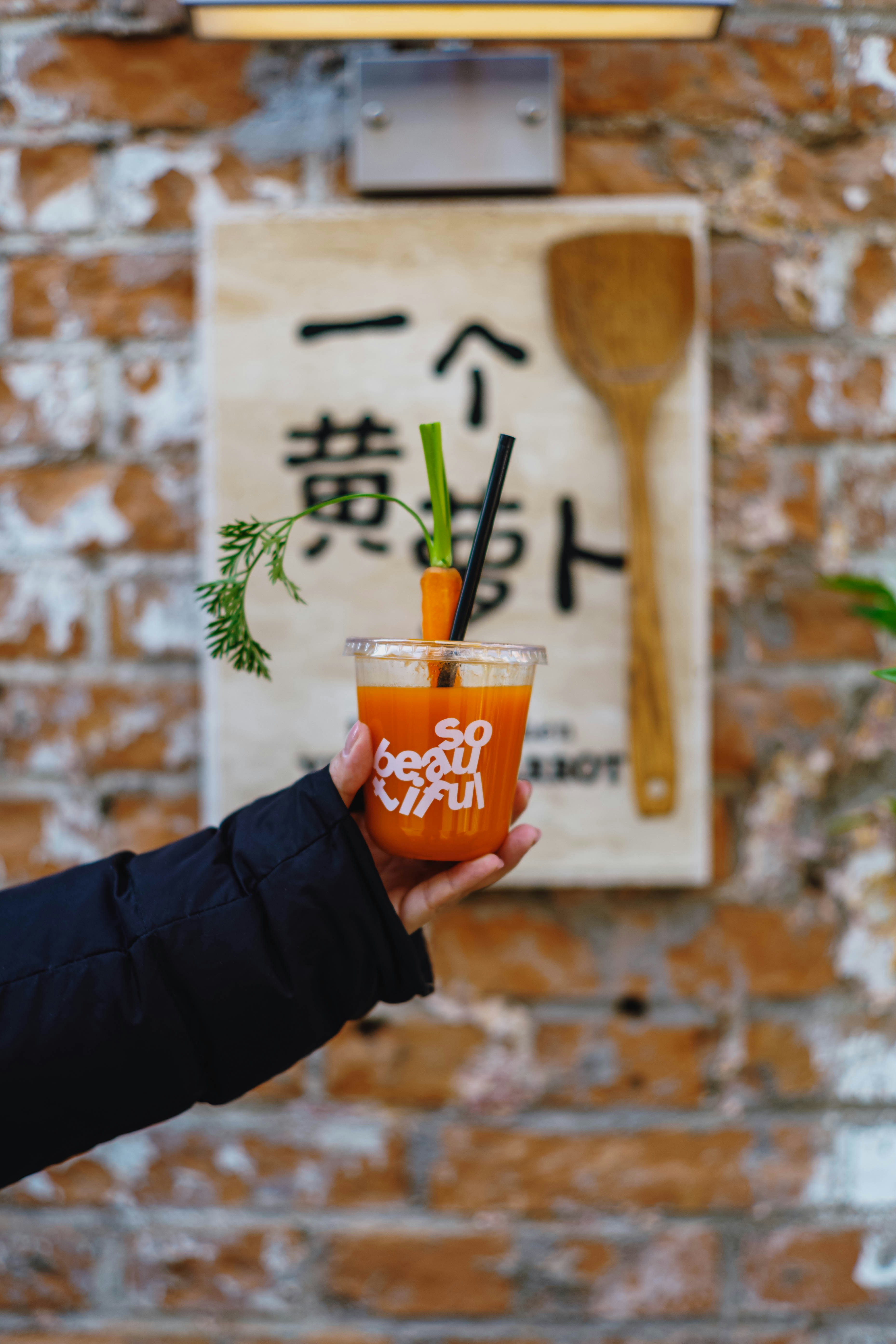 Carrot Cup: A Bright Pour in a Brick-Wordered Scene