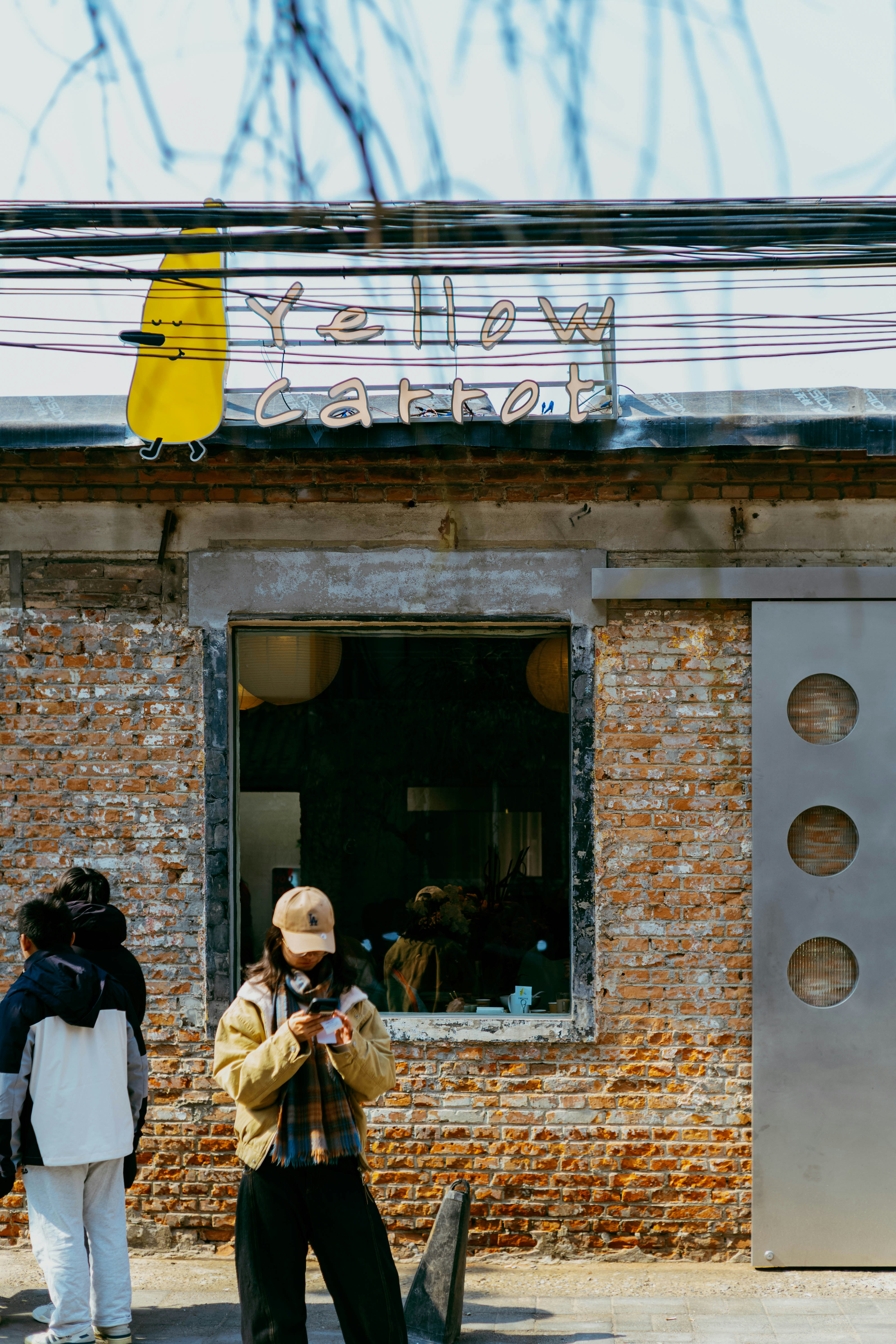 City Café Portrait: A Student in Warm Tones Outside a Brick Front