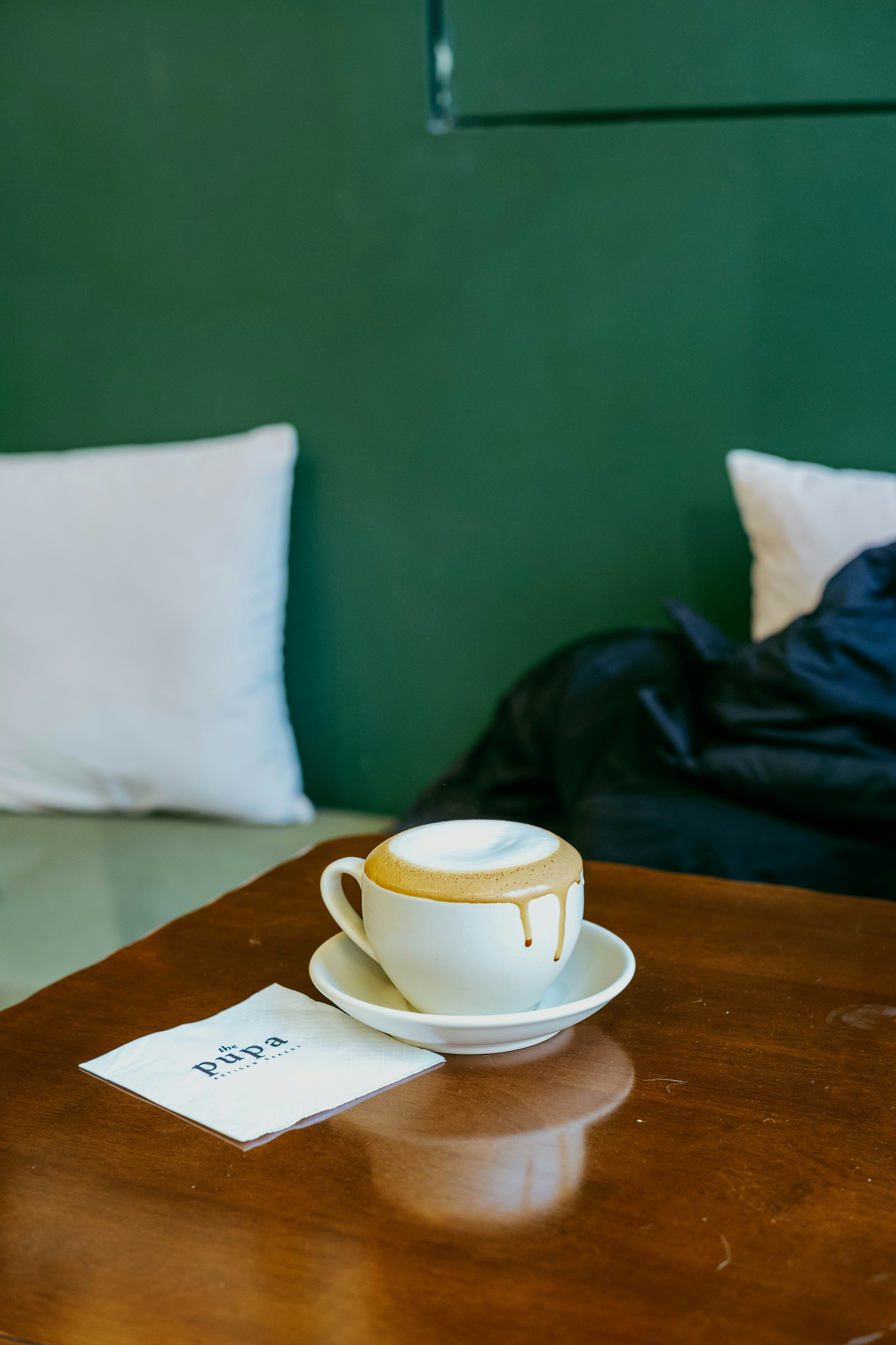 A Quiet Moment Over Coffee: Latte Art and Soft Cushions