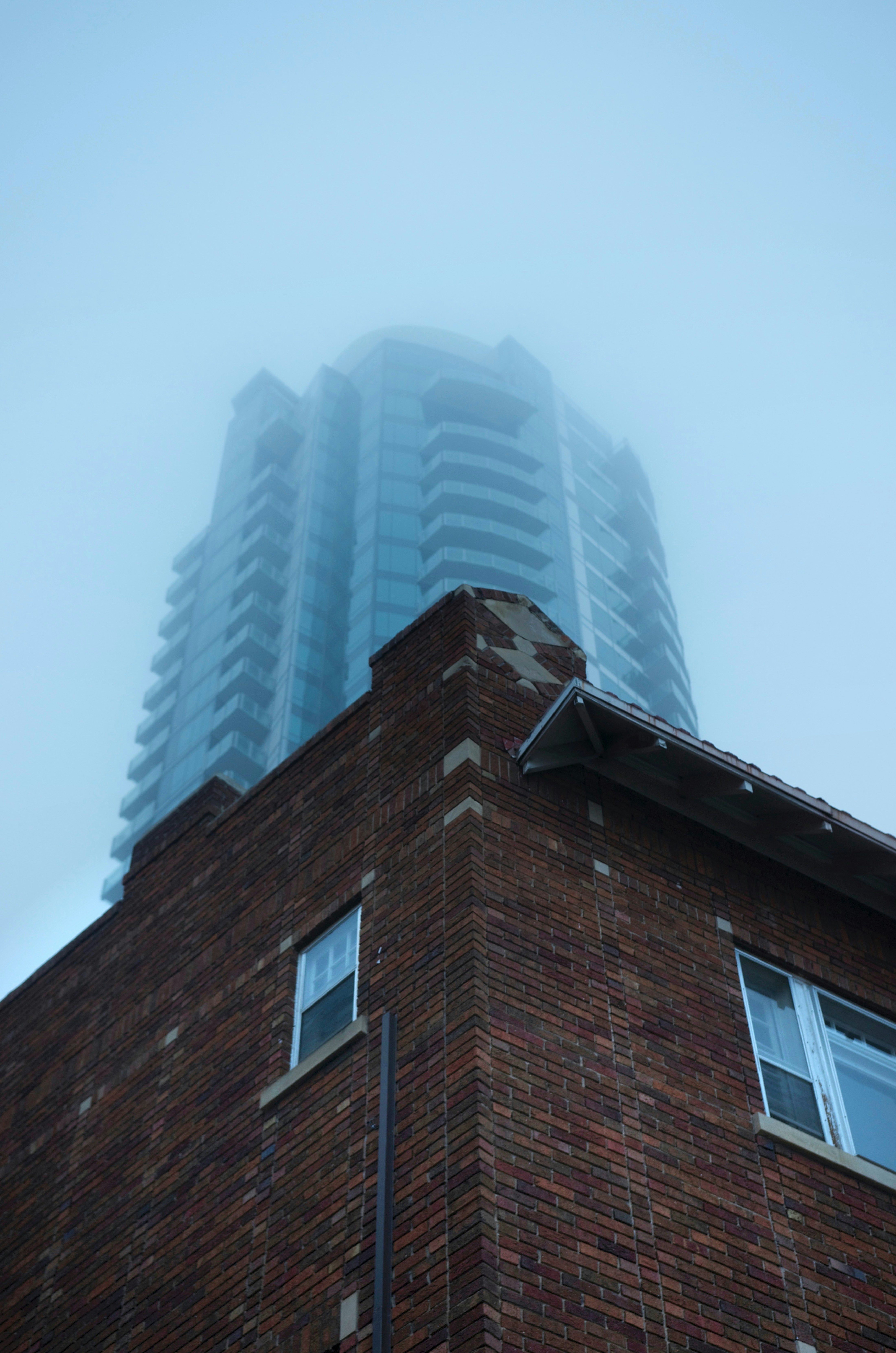 Fog-Soft Tower Emergence Over Brick House