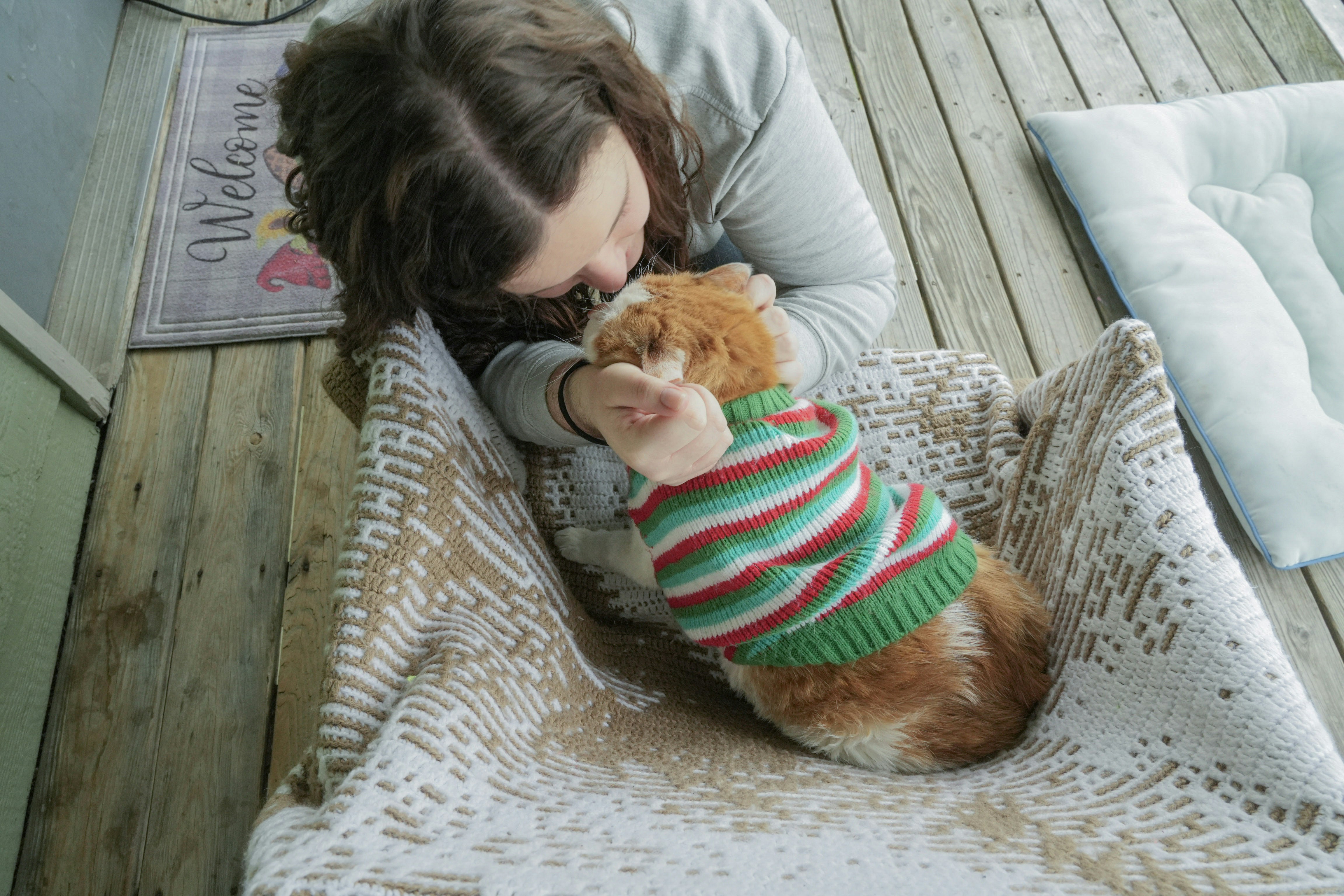 Warm Moment: A Cozy Hug with a Striped Pup on the Porch