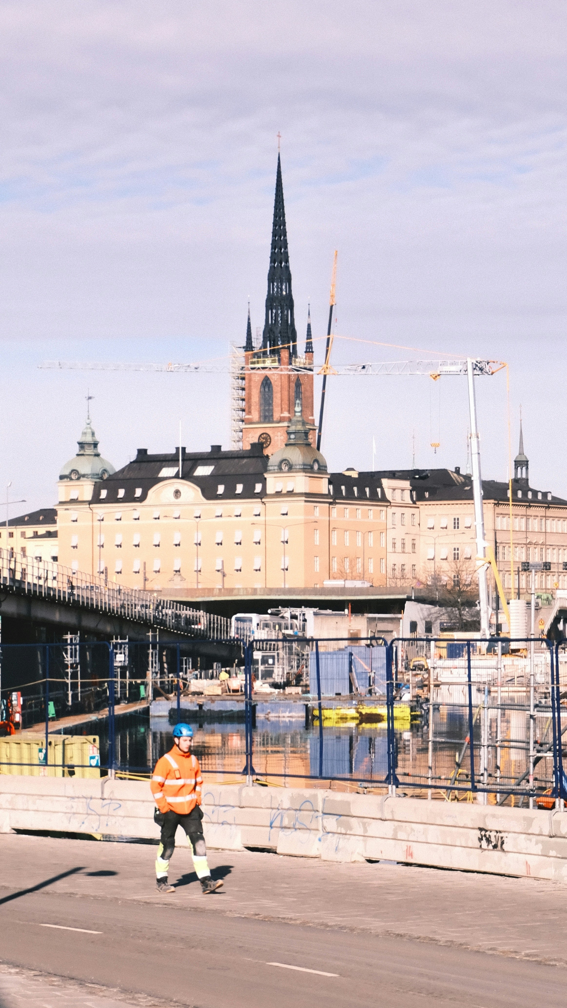 Crane-lined Cityscape with a Worker in the Foreground