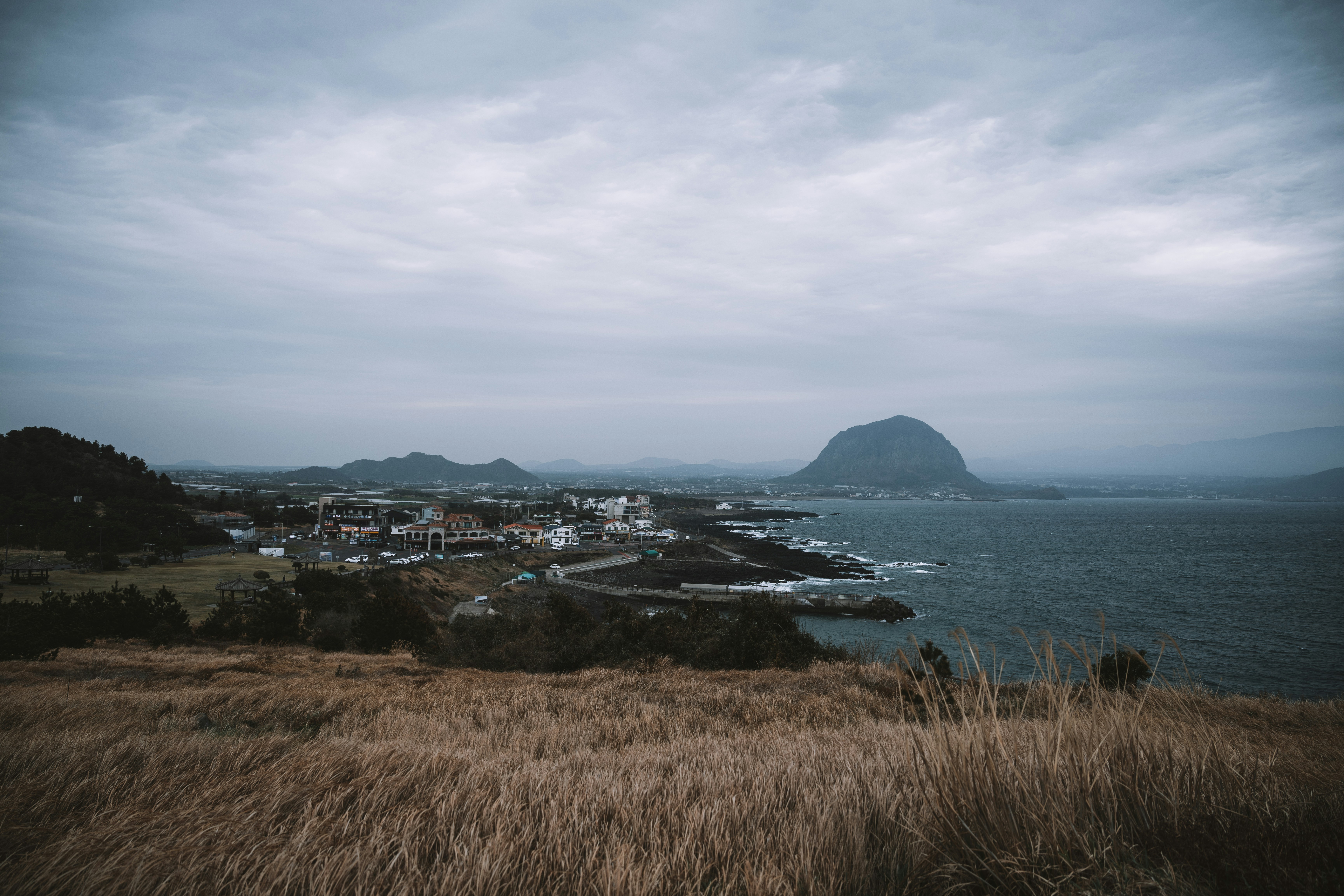 Coastal Village Beneath a Looming Island