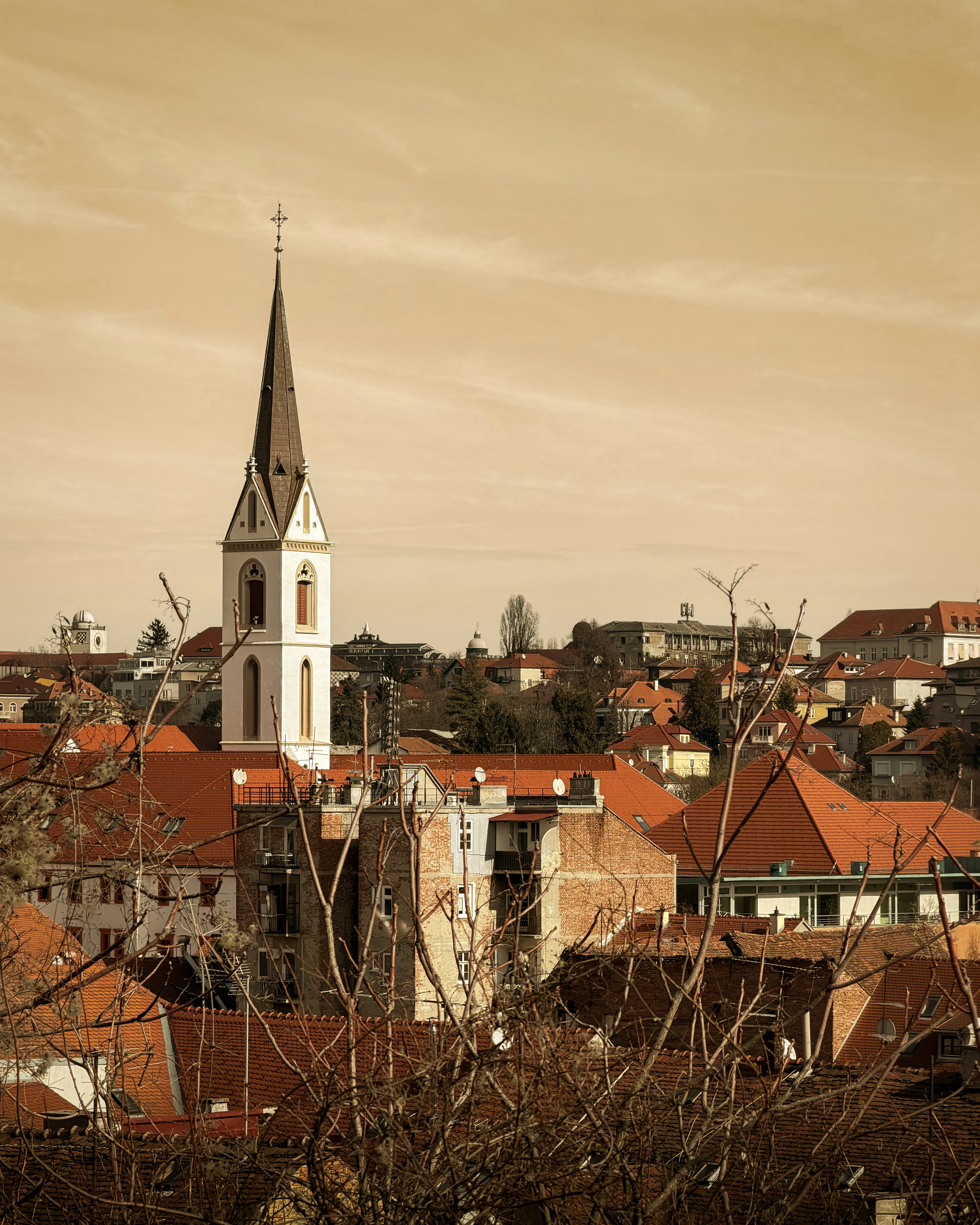 Church Tower over Terracotta Rooftops at Dusk