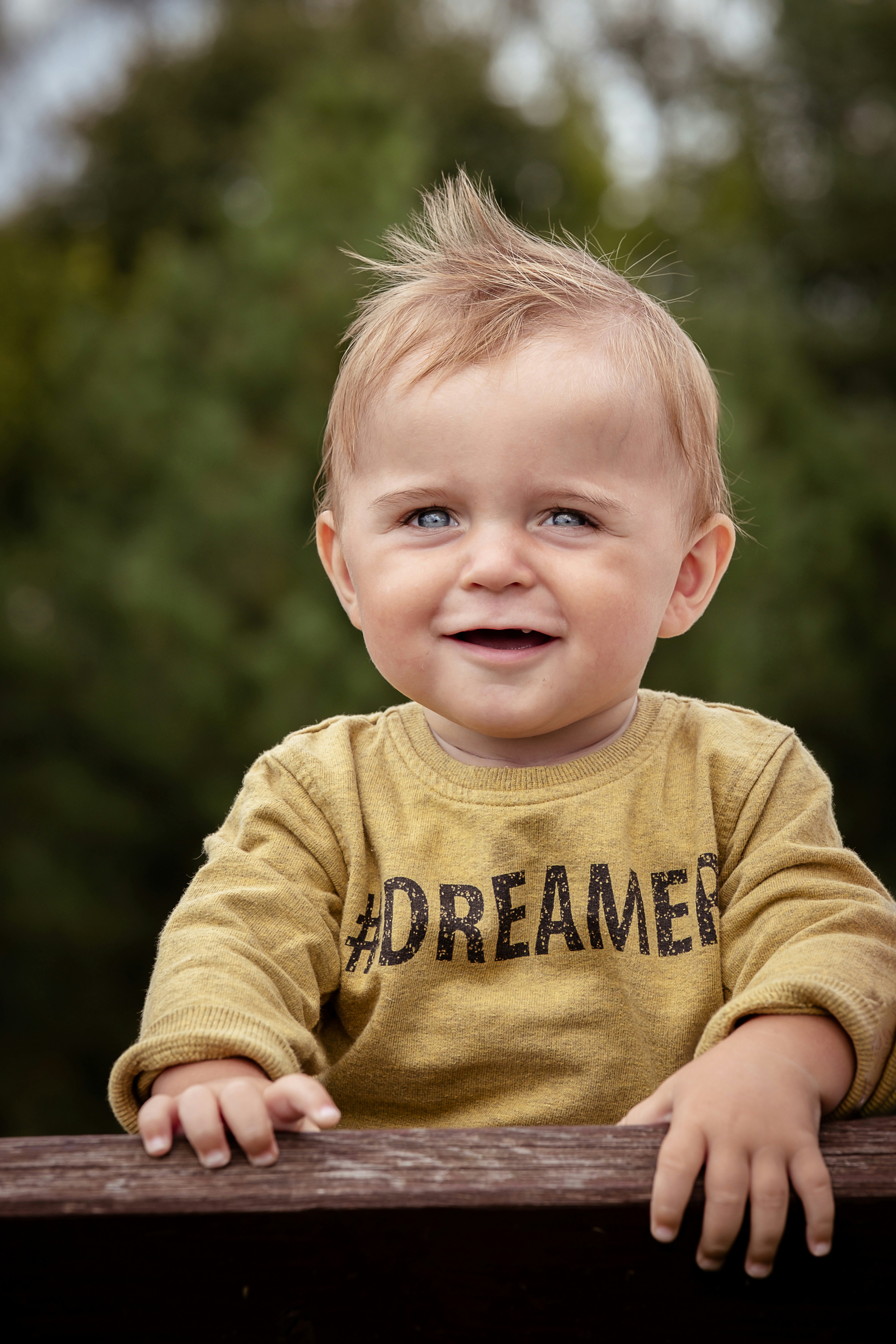 Concerned Smile: A Curious Toddler Grips the Rail, Morning Light Illuminating Blue Eyes
