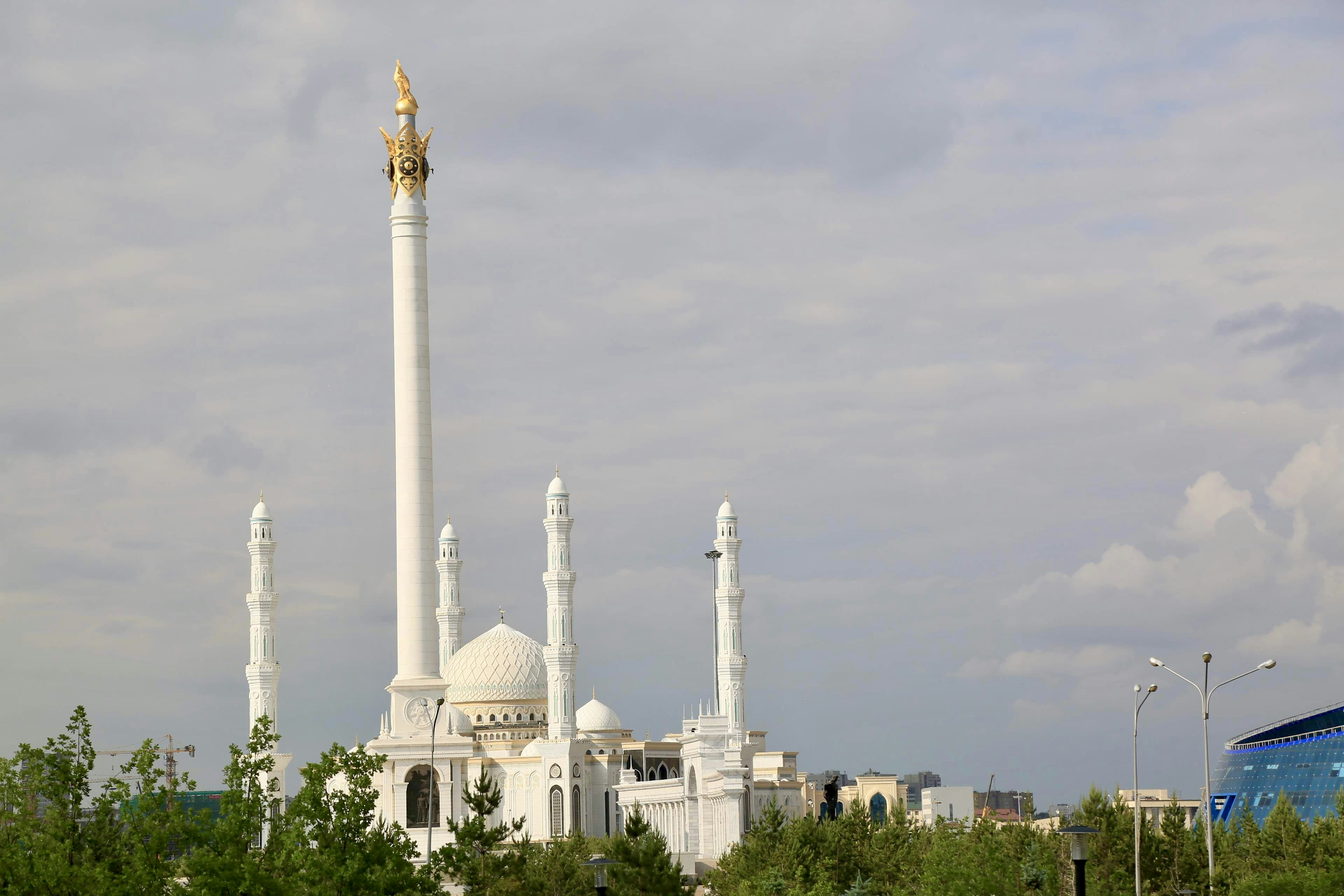 White Mosque and Obelisk Piercing a Sky of Clouds