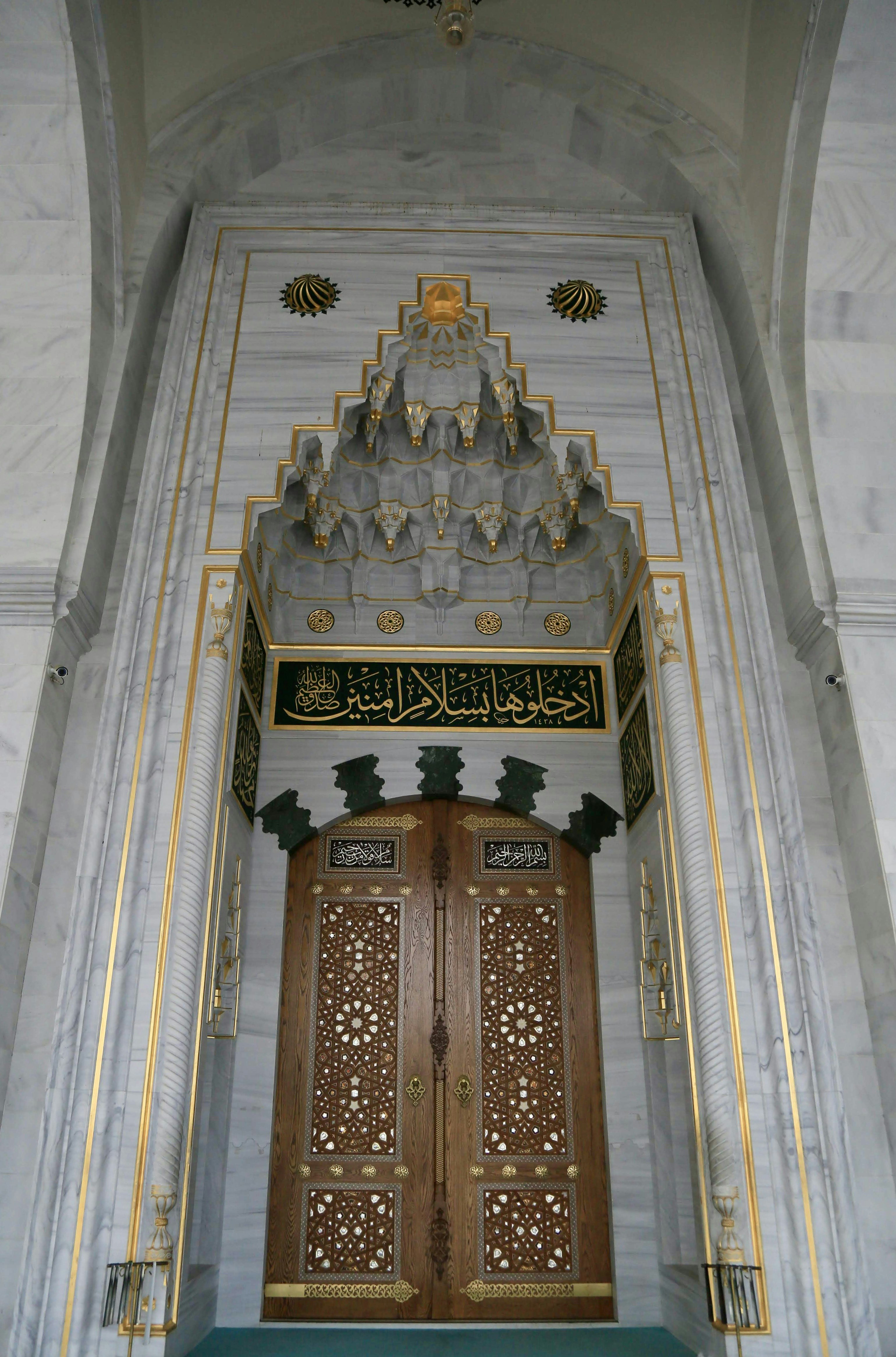 Intricate Imam Gate: Gold-Trimmed Archway and Carved Door