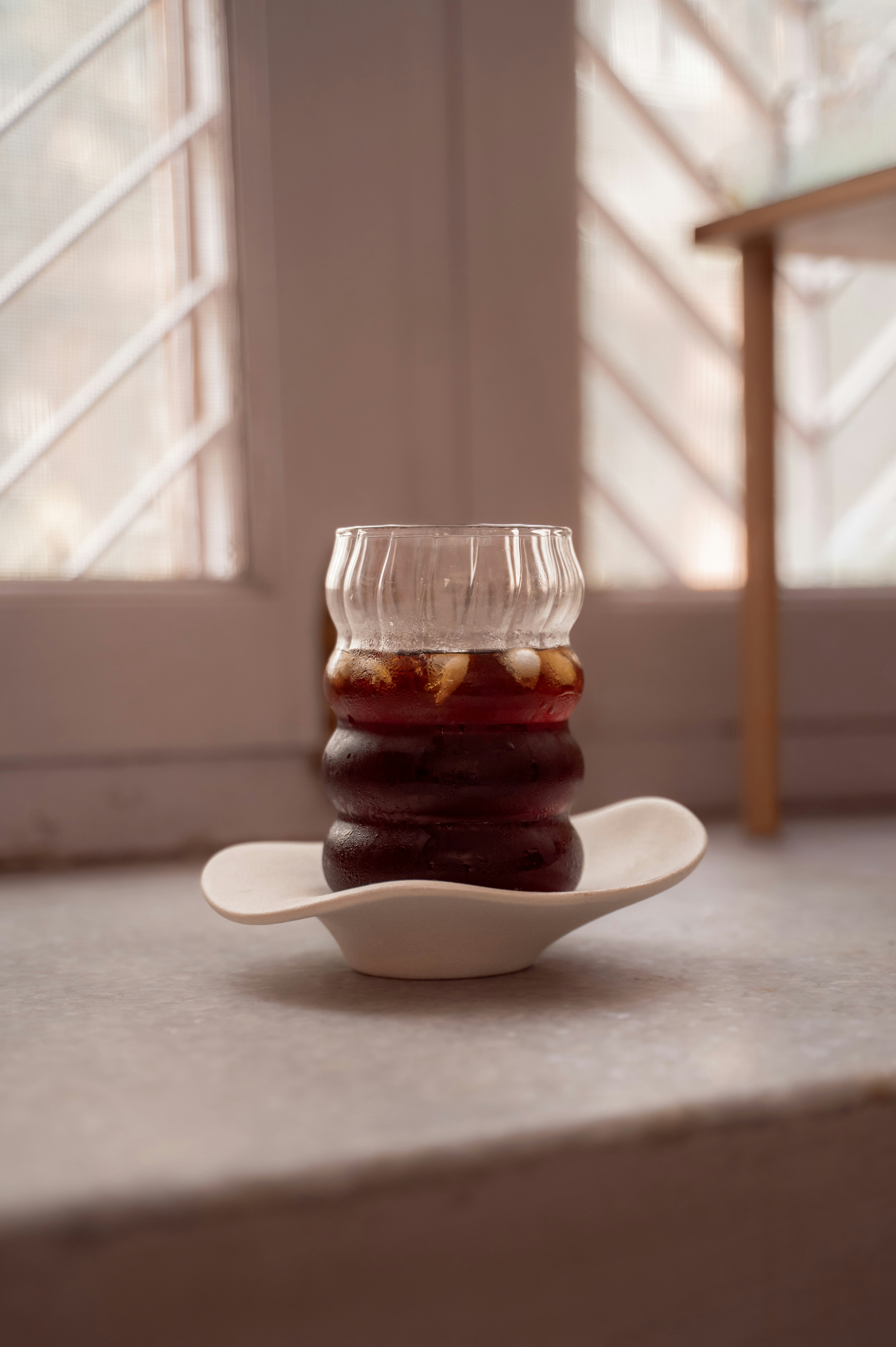 Stacked Treat: A Glass Cup Resting on a Curved Plate
