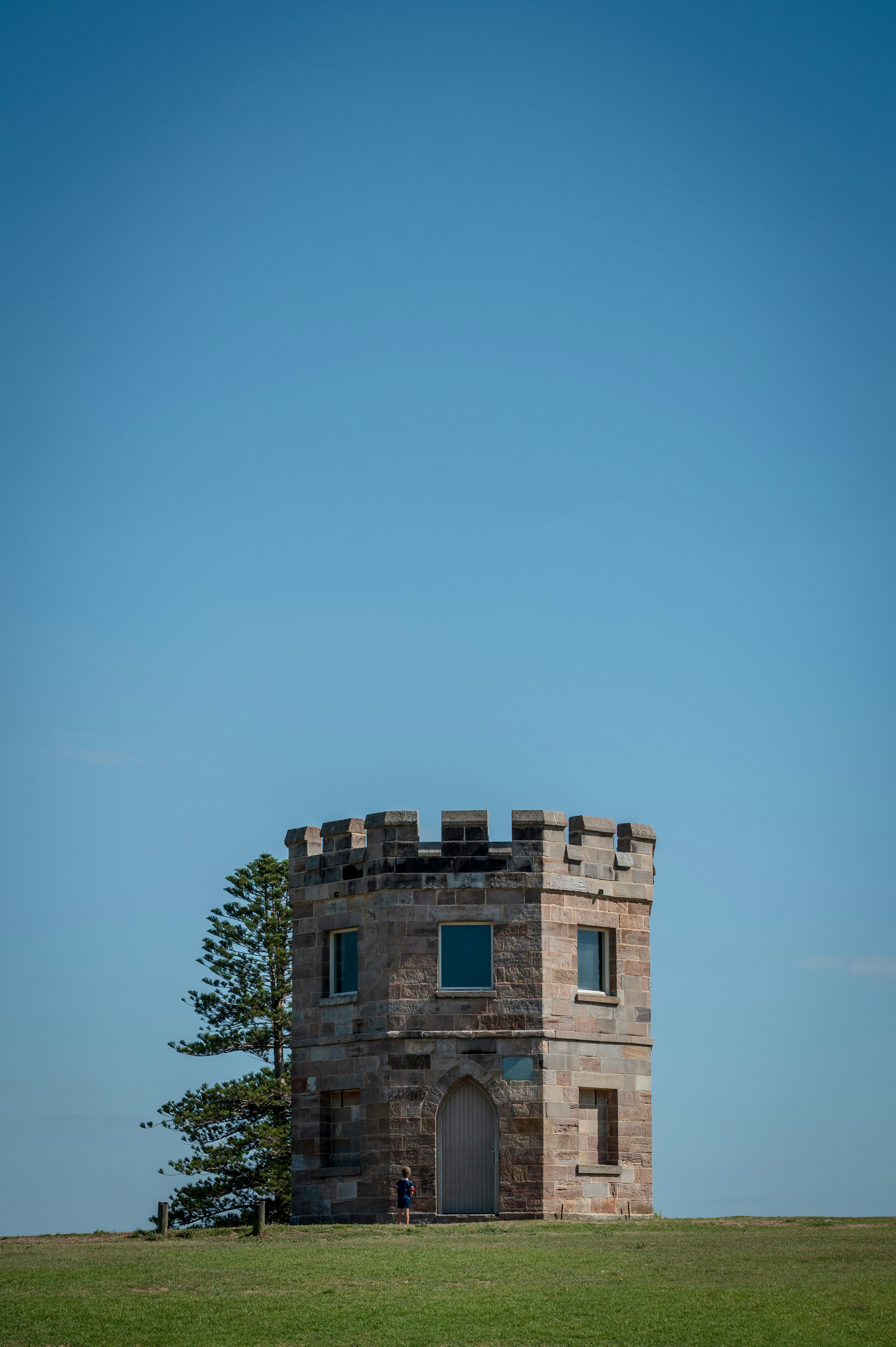 Stone Turret on the Hill: A solitary keep under a wide blue sky