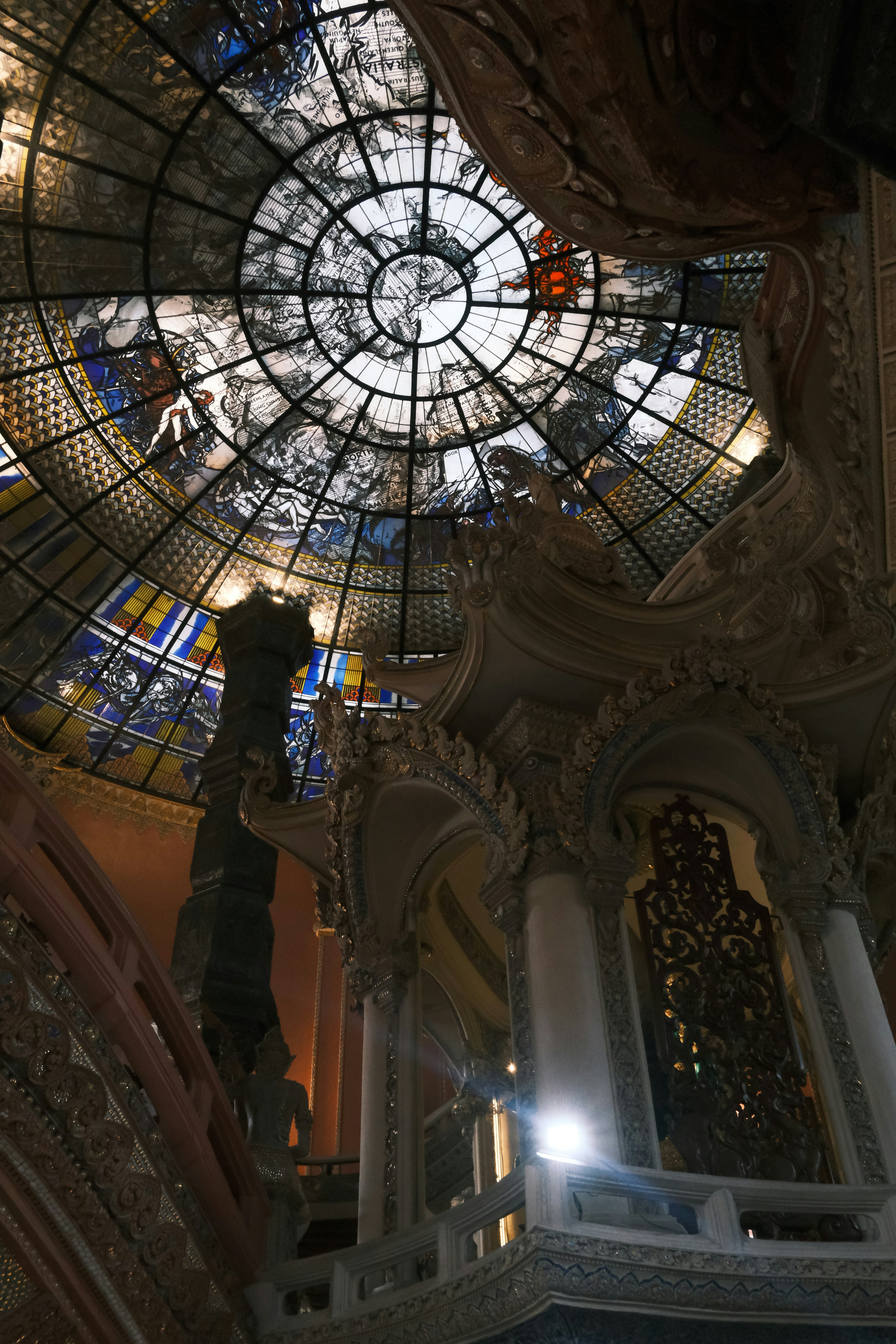 Stained Glass Dome Overlook: Ornate Staircase Beneath an Illuminated Vault