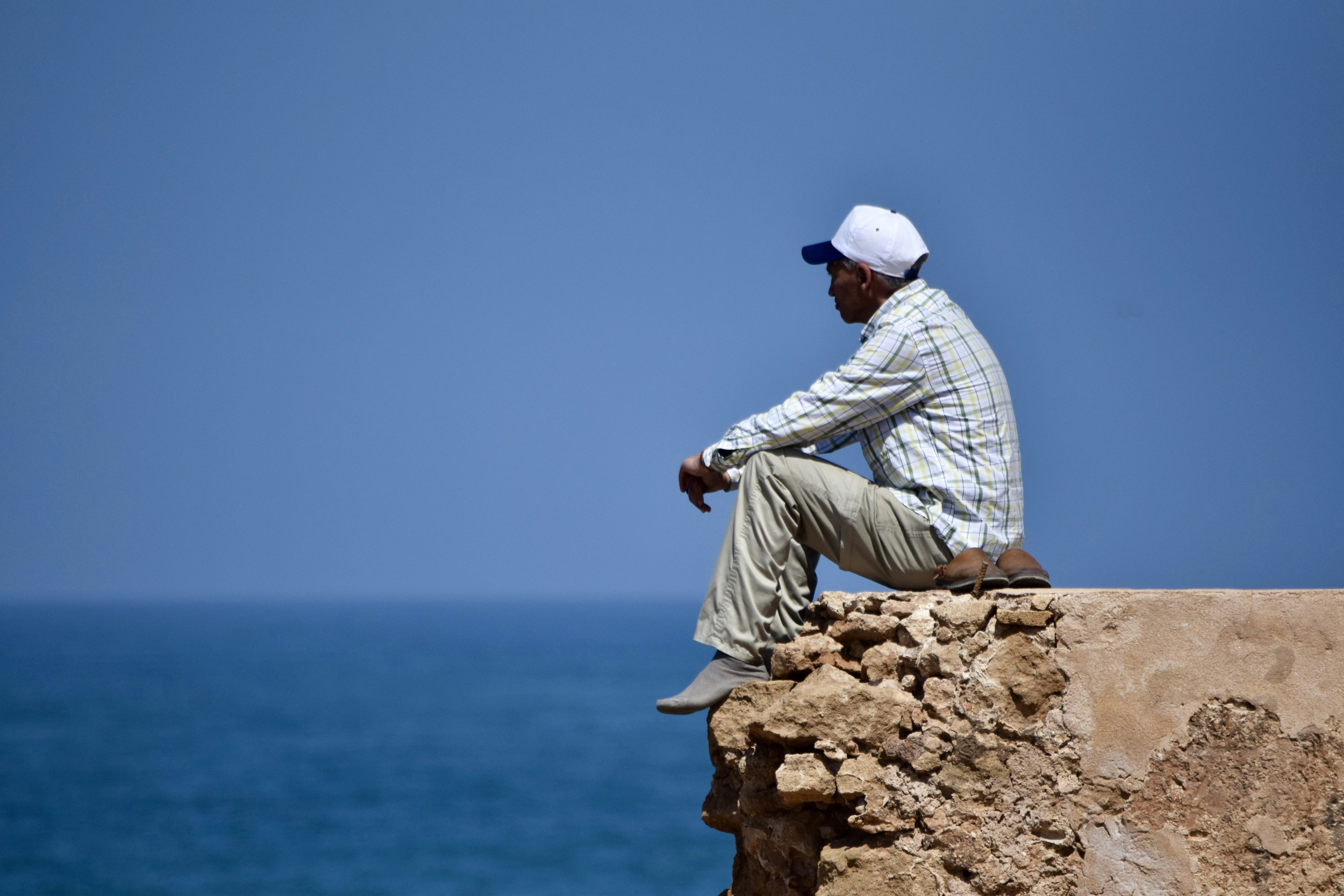 Seated on the Edge: A Contemplative Moment Over the Sea