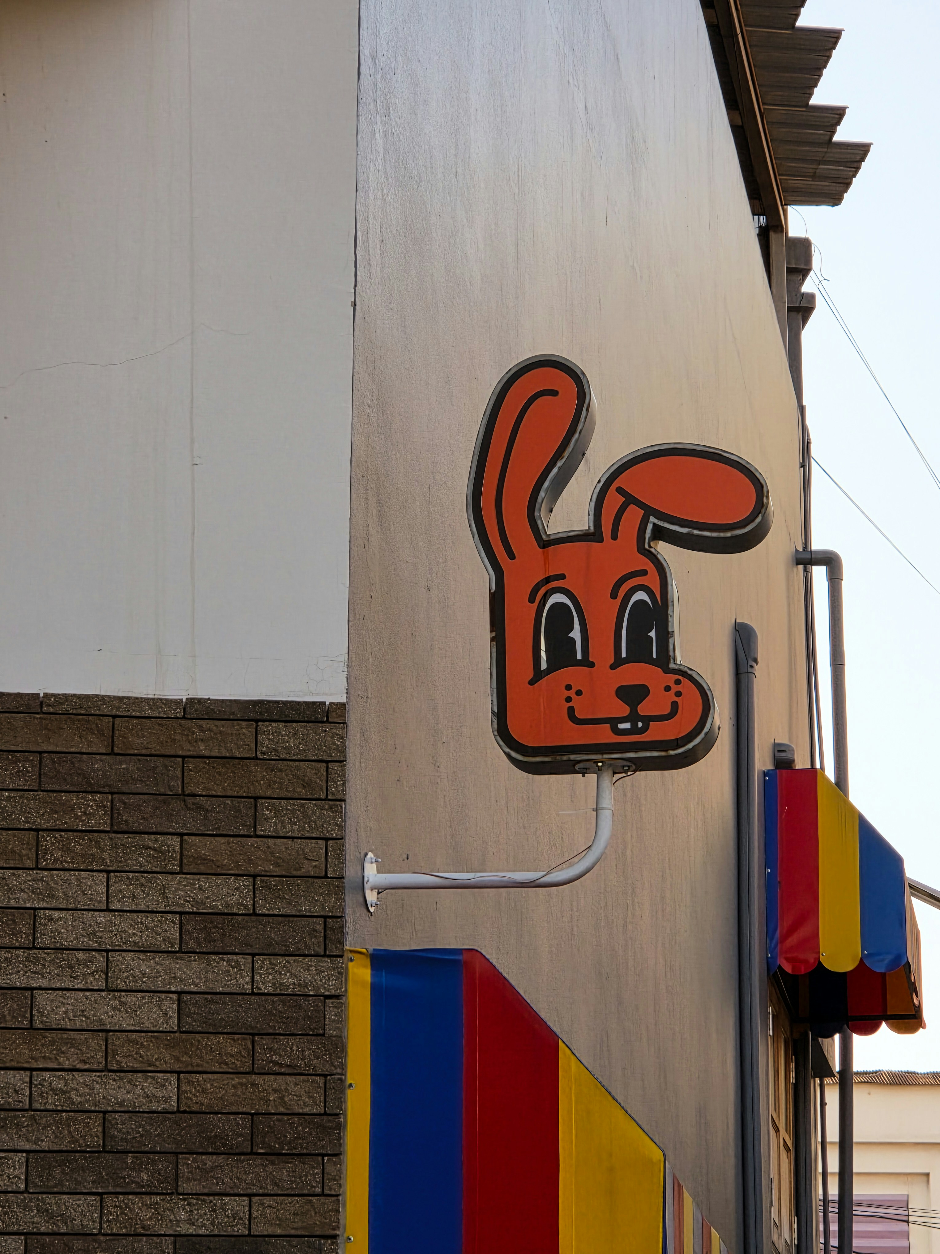 Orange Rabbit Sign on Sunlit Wall