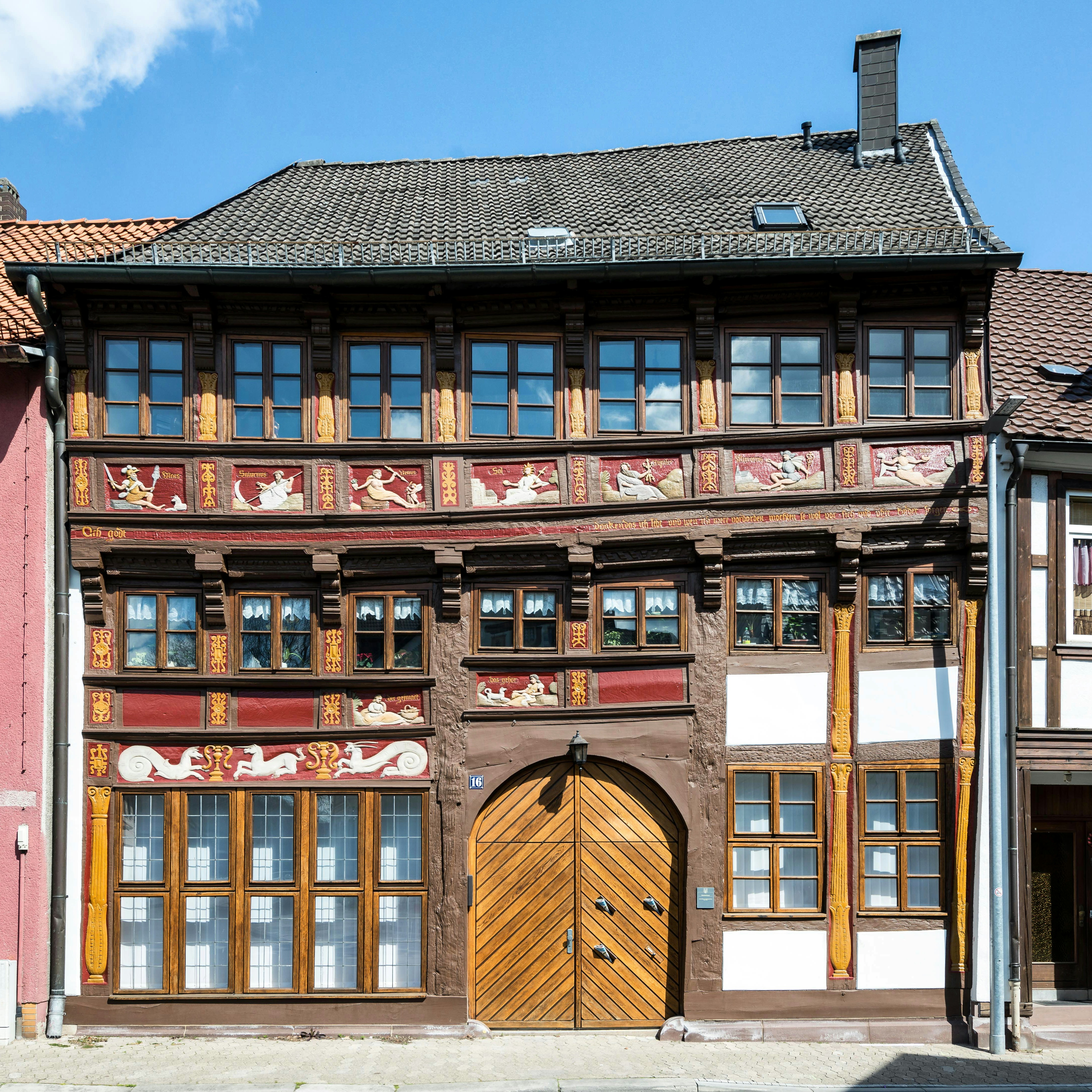 Heraldic Facade: A Timeless Wooden Entry Framed by Painted Shields
