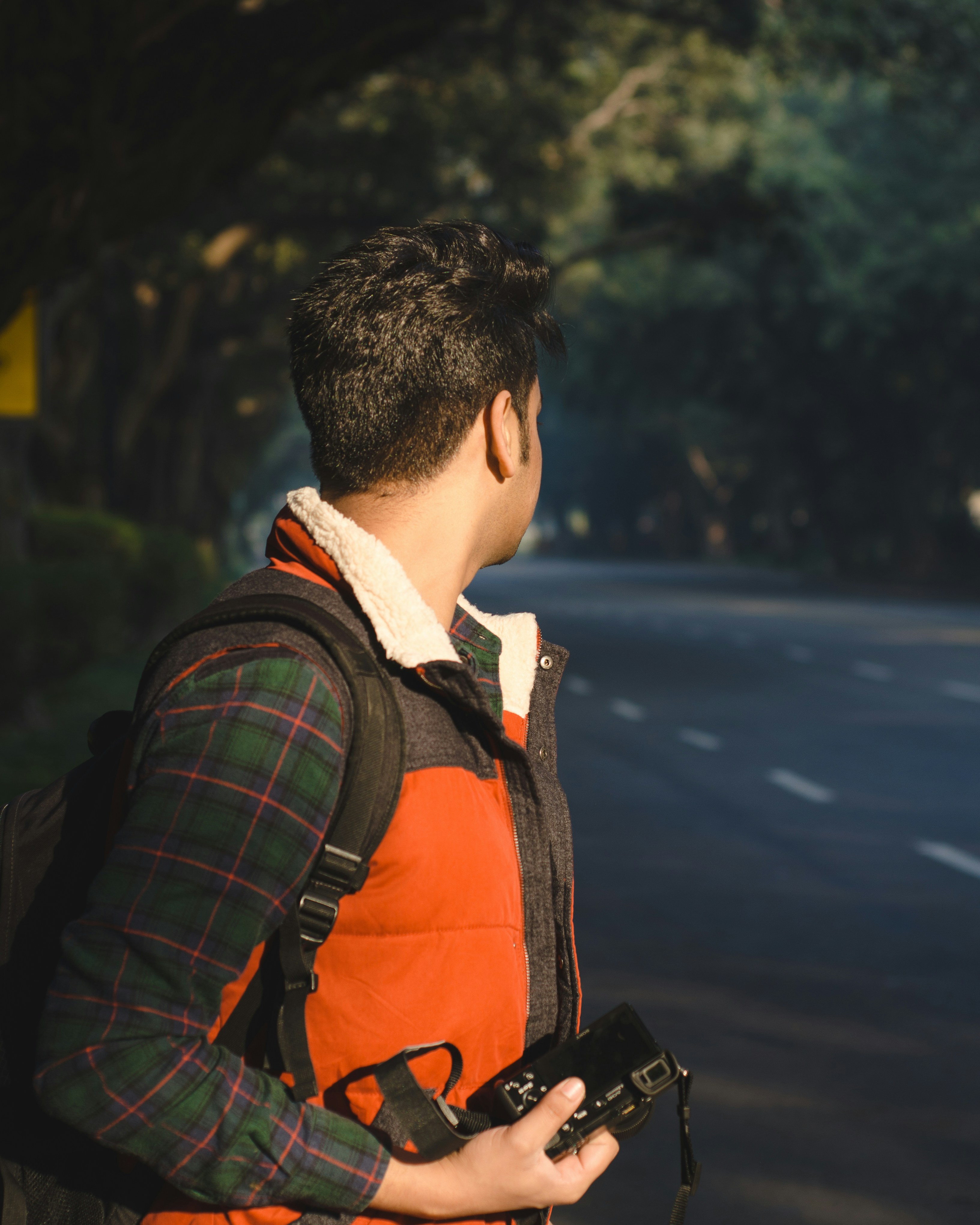 Backlit Traveler with a Vintage Lens by the Open Road