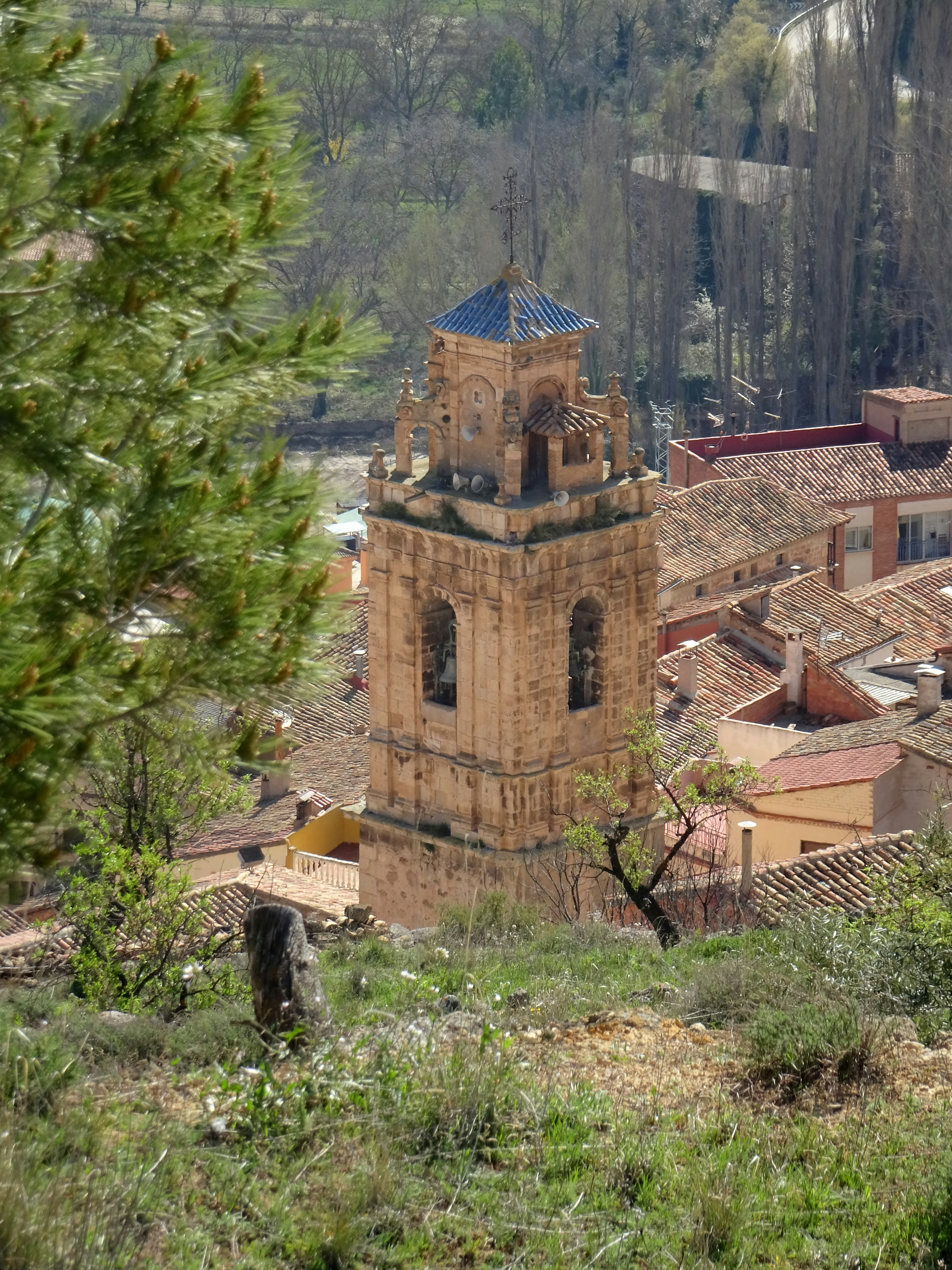 Stone Bell Tower Rising Over a Terrace of Warm Terracotta Roofs